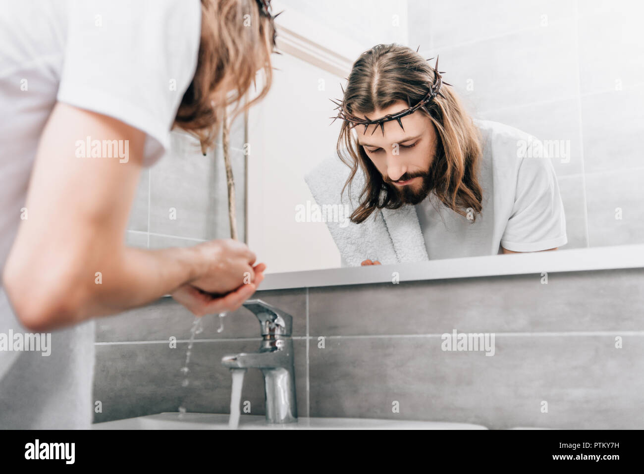 partial view of Jesus with towel over shoulder washing hands in ...