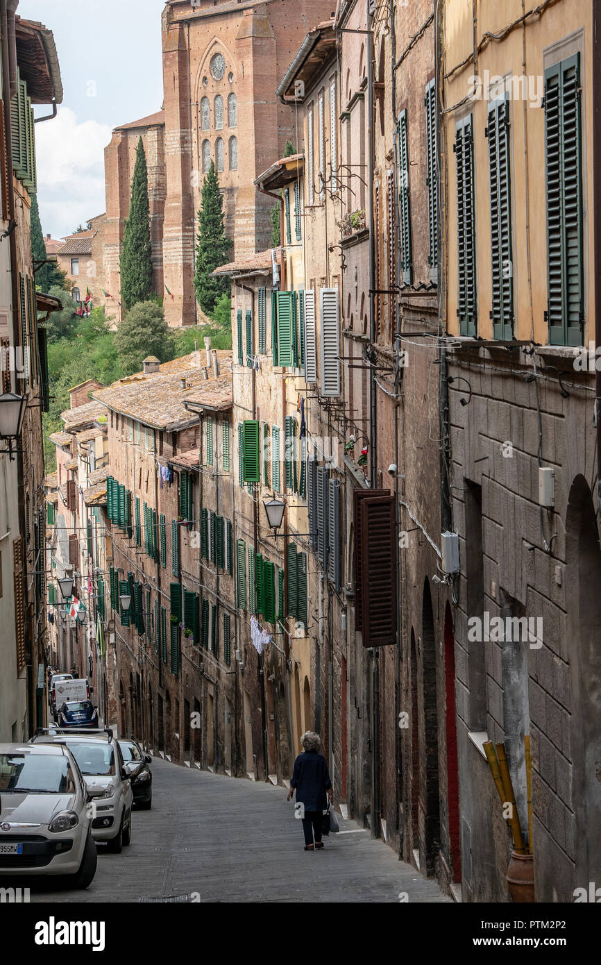 Old lady walks down a road in Siena old town Stock Photo - Alamy
