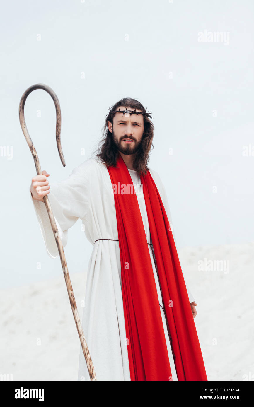 Jesus with long hair standing with wooden staff in desert Stock Photo ...