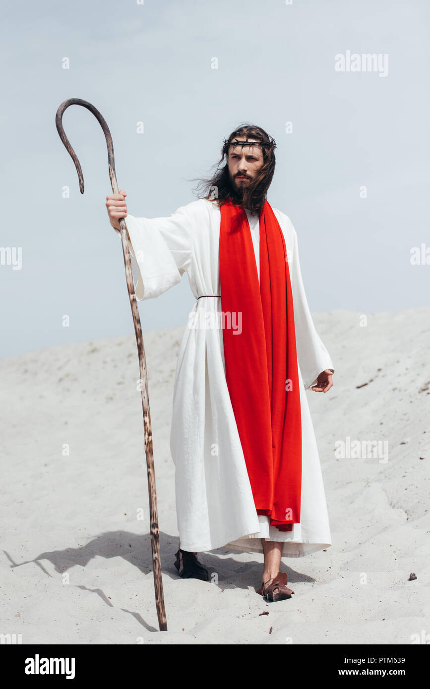 Jesus in robe, red sash and crown of thorns standing with wooden staff ...