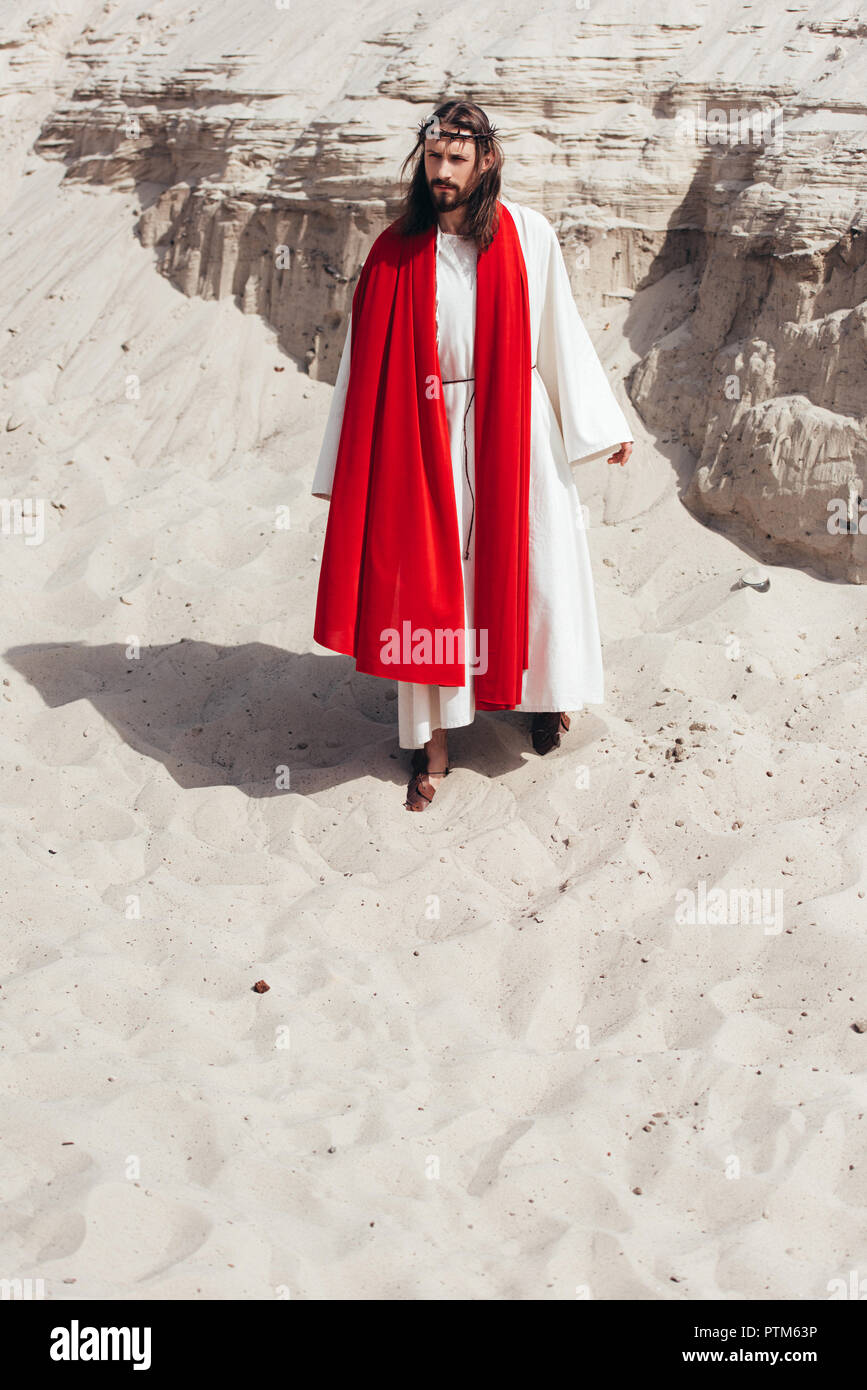 Jesus in robe, red sash and crown of thorns walking in desert Stock ...