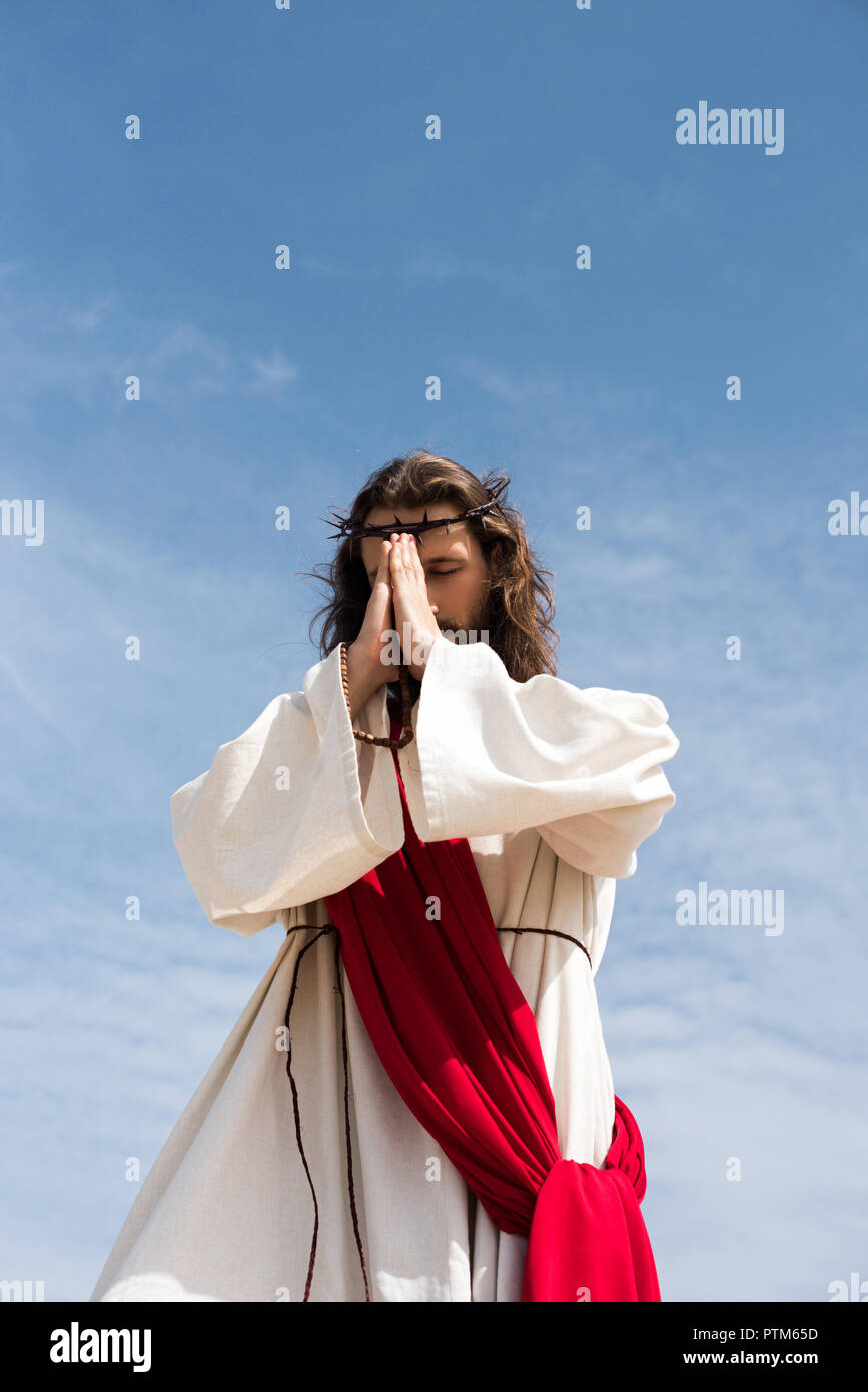 low angle view of Jesus Christ in robe, red sash and crown of thorns ...