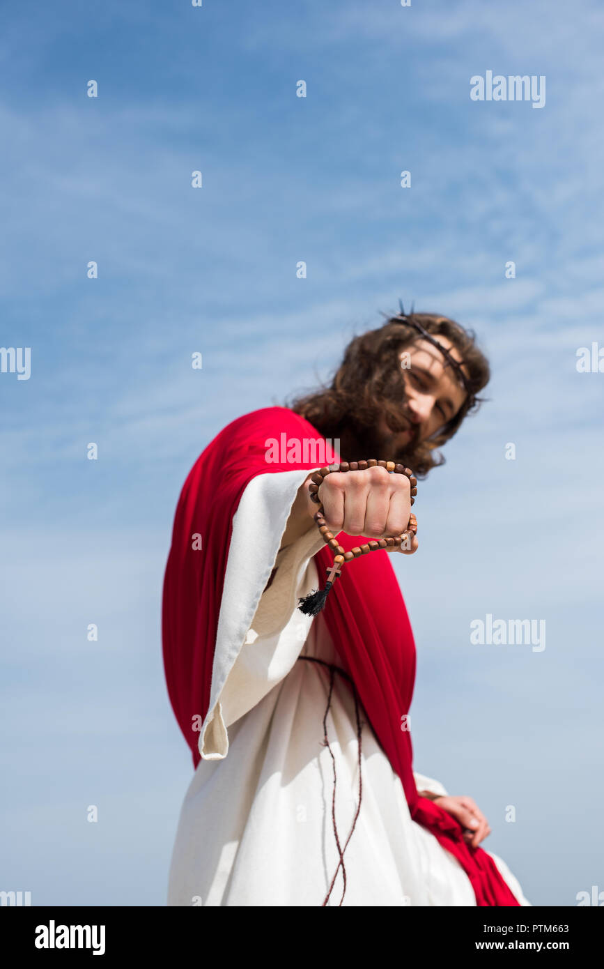low angle view of Jesus in robe, red sash and crown of thorns showing ...