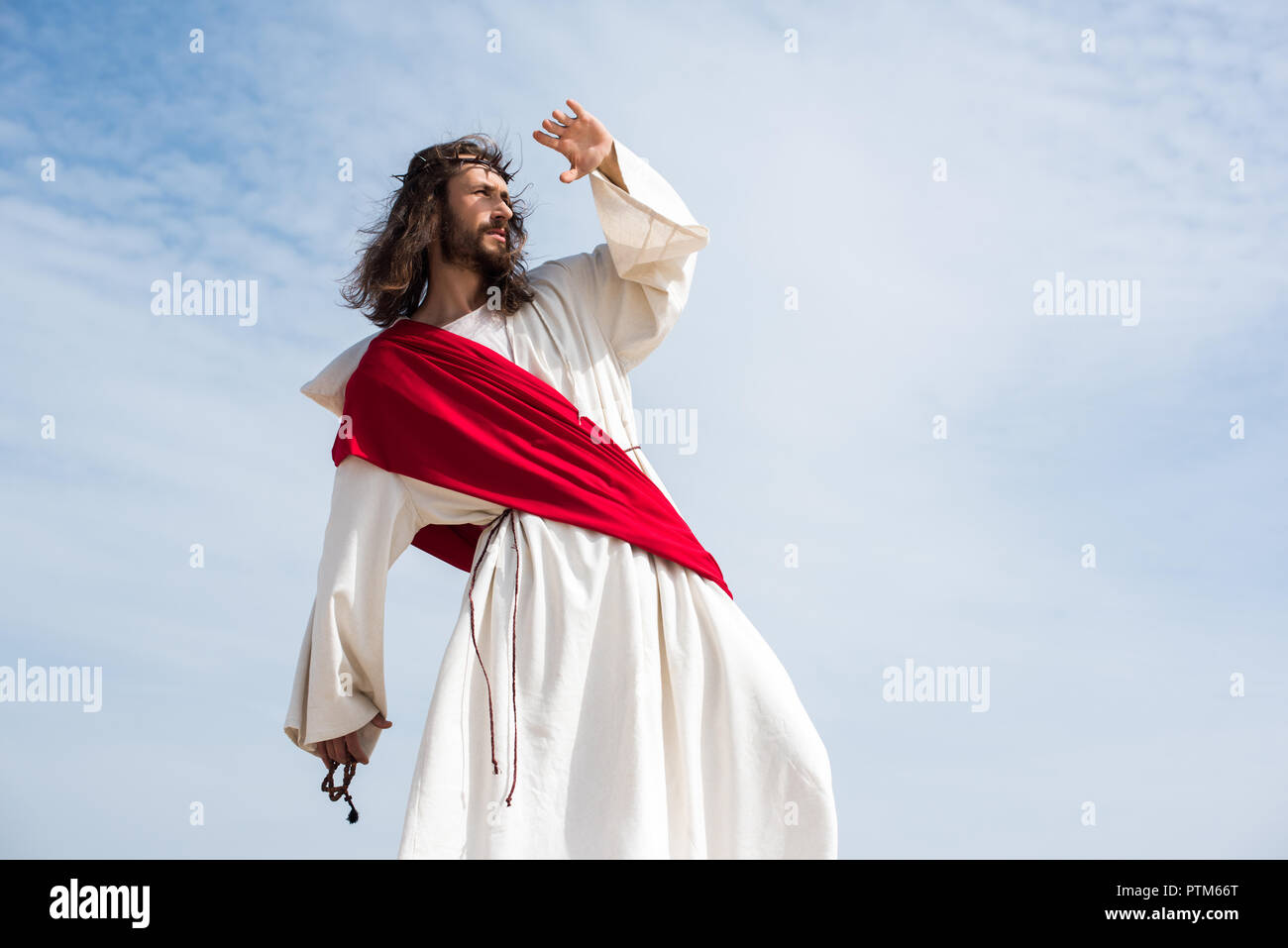 Jesus in robe, red sash and crown of thorns holding rosary and ...