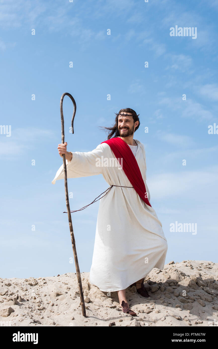 smiling Jesus in robe, red sash and crown of thorns standing with ...