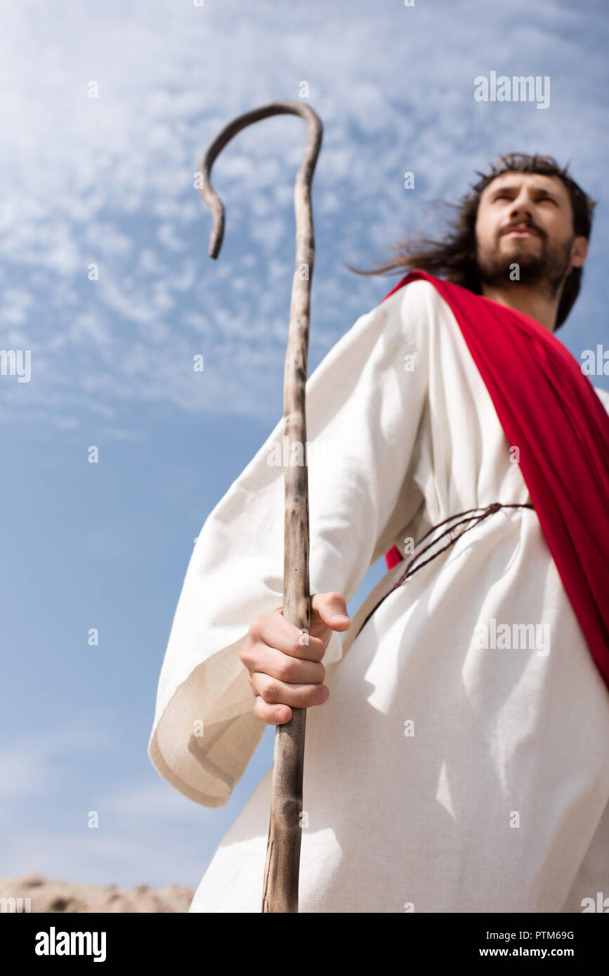 high angle view of Jesus in robe, red sash and crown of thorns standing ...