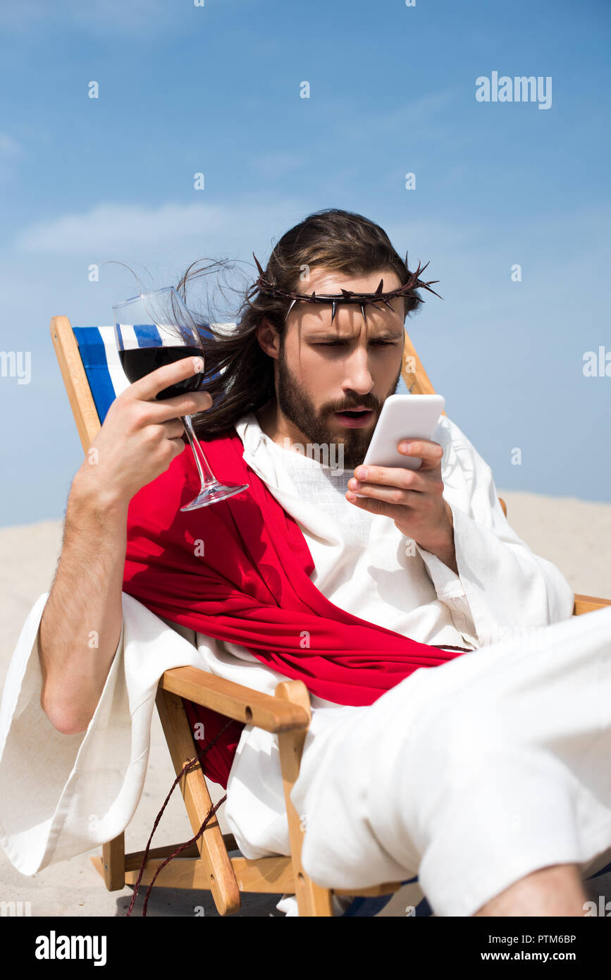 surprised Jesus resting on sun lounger with glass of wine and looking ...