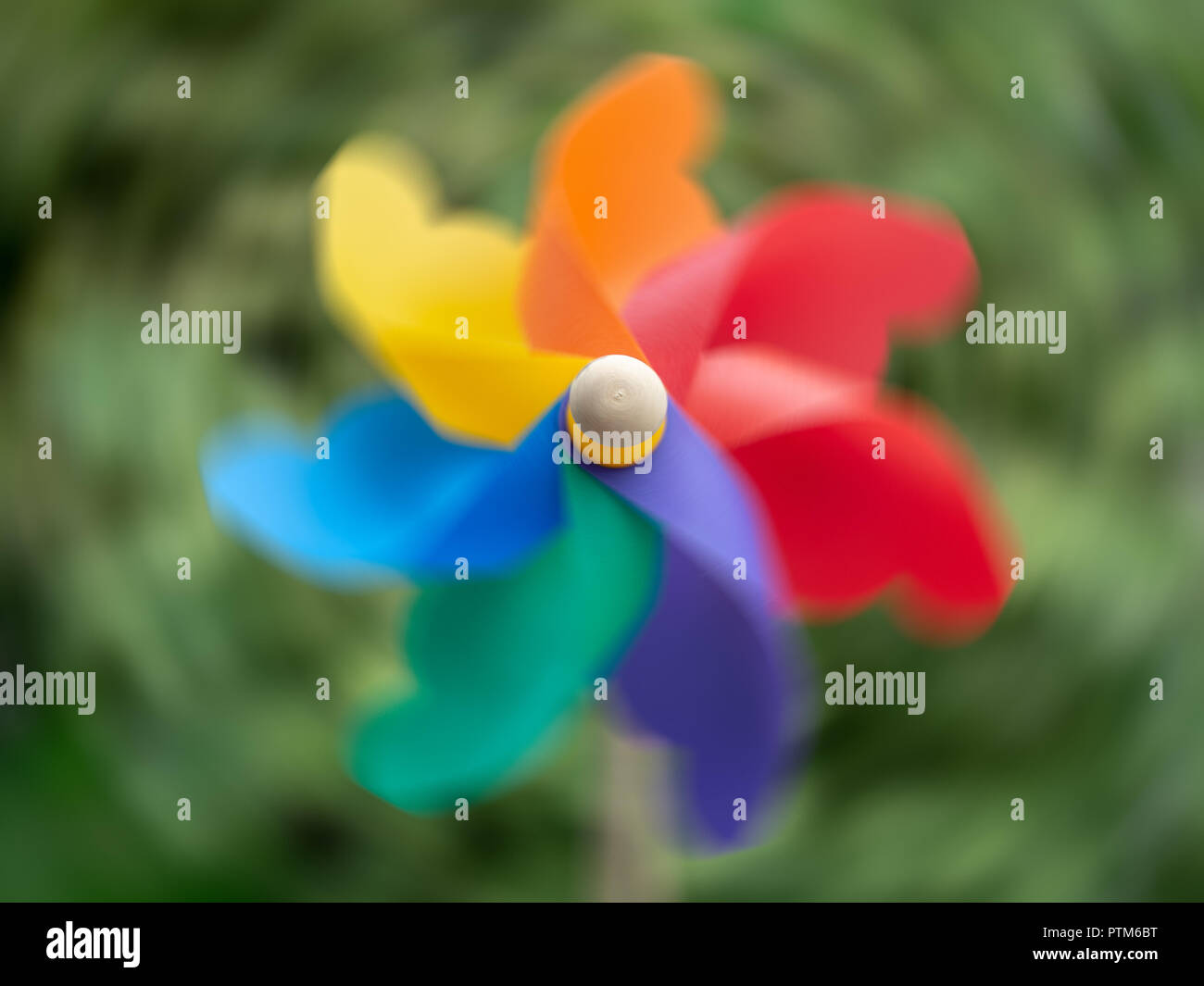 Blurred colorful pinwheel spinning motion on green nature background ...