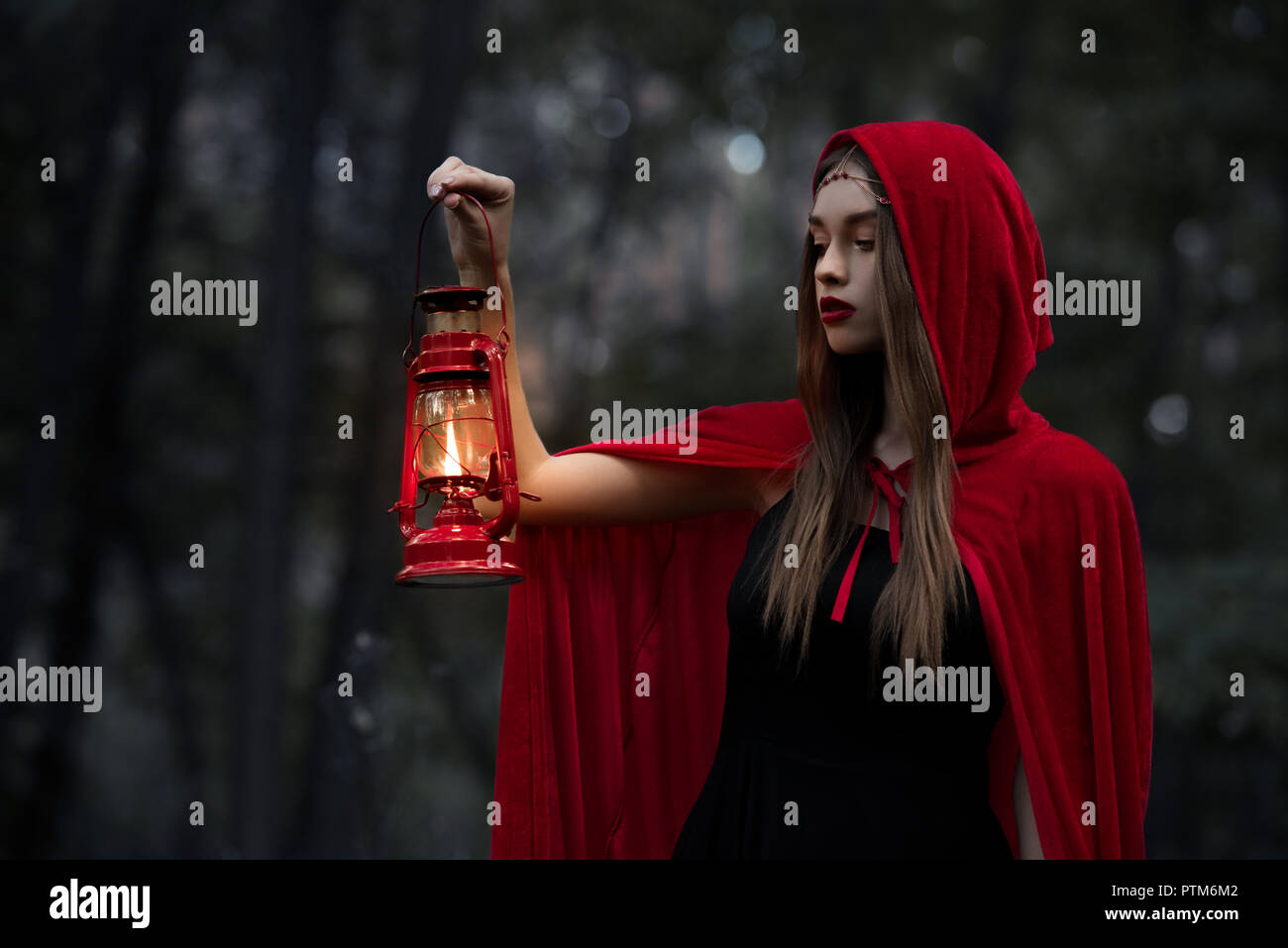 mystic girl walking in dark forest with kerosene lamp Stock Photo - Alamy