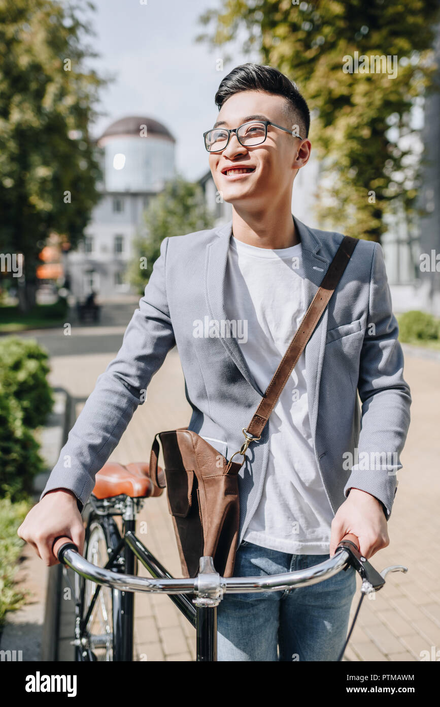 happy handsome asian man walking with bicycle in city Stock Photo - Alamy
