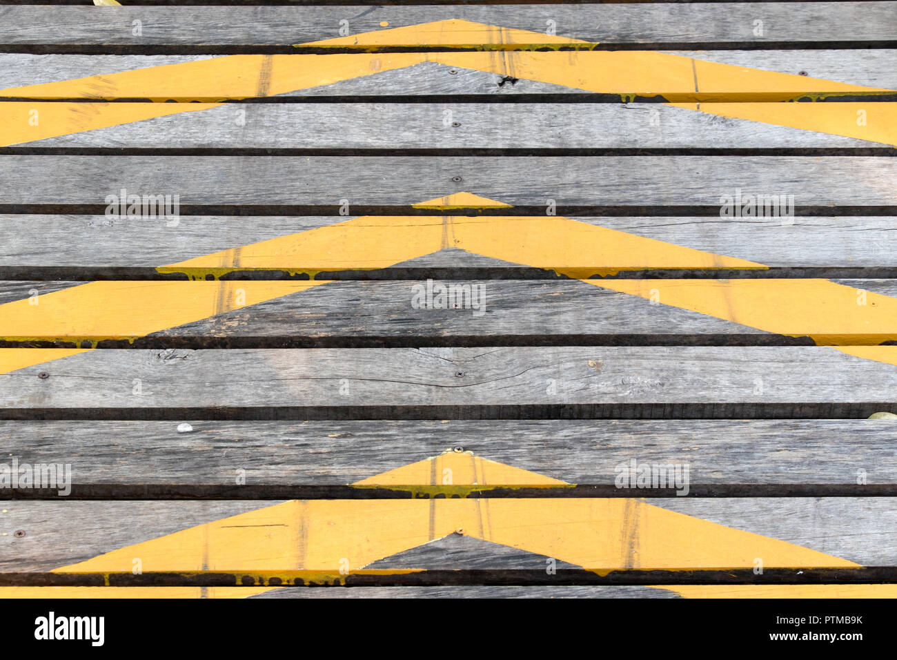 Yellow painting in forward direction arrow symbol on wood background ...