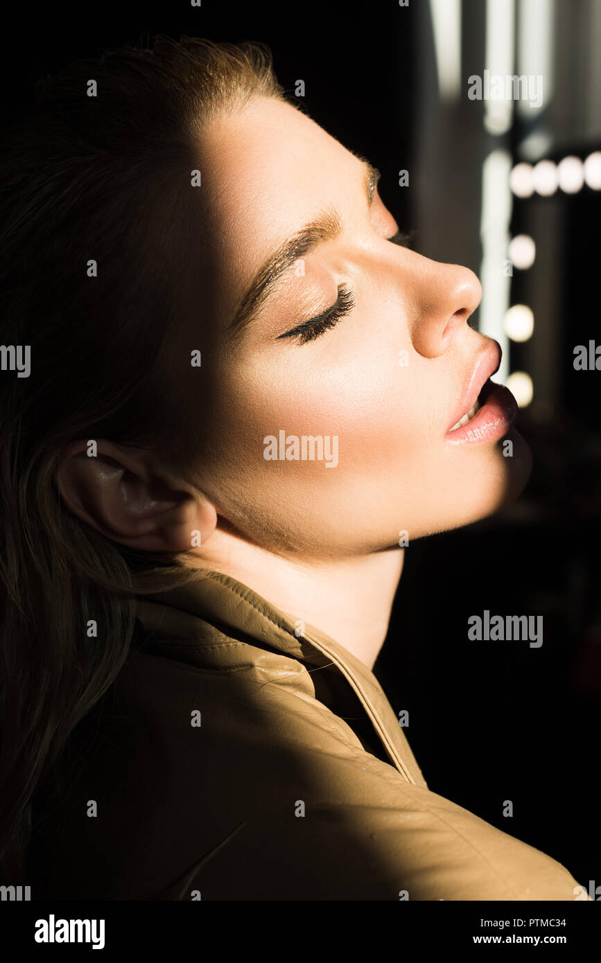 side view of fashionable woman in trench with eyes closed Stock Photo ...