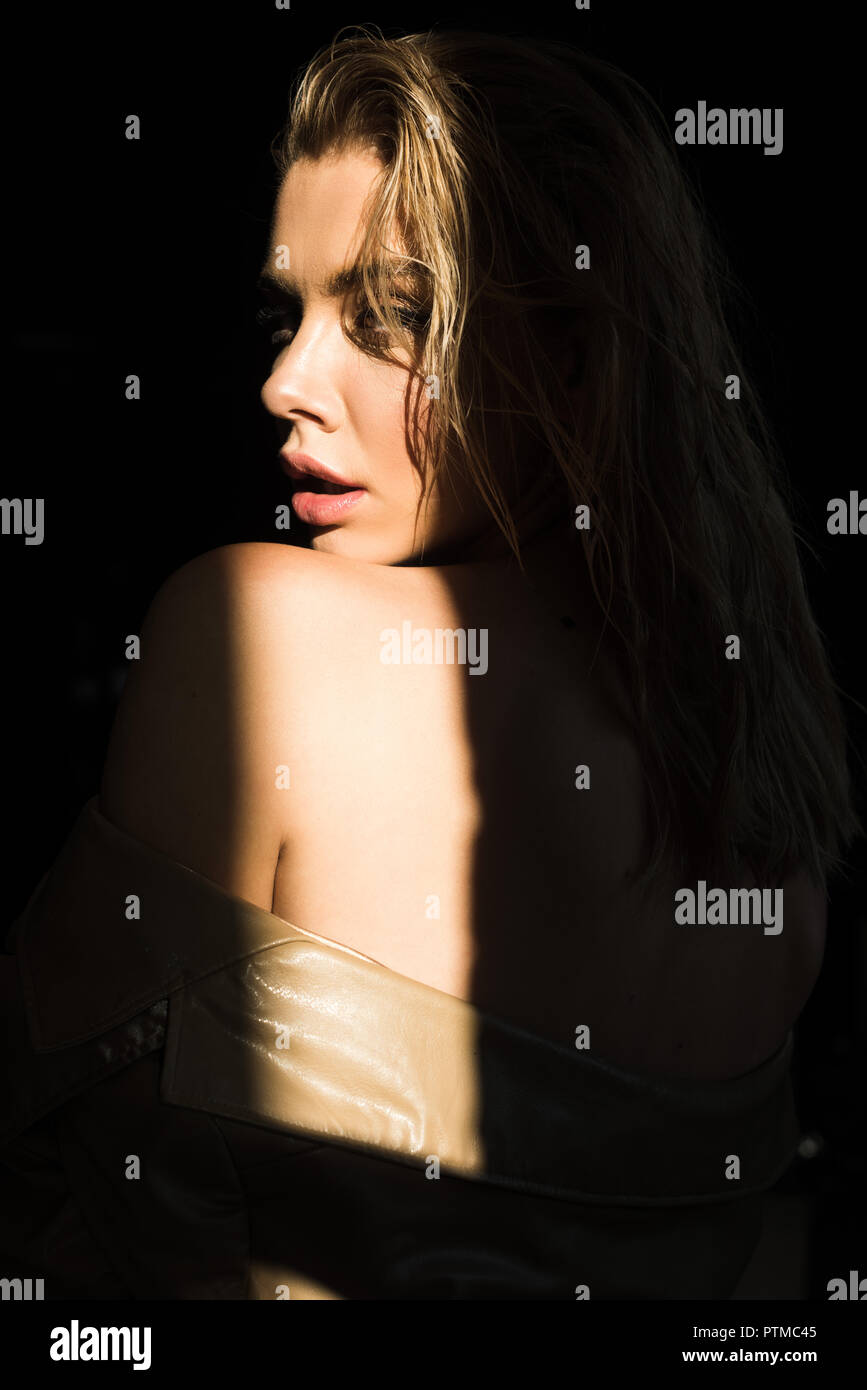 side view of beautiful and stylish model looking at camera Stock Photo ...