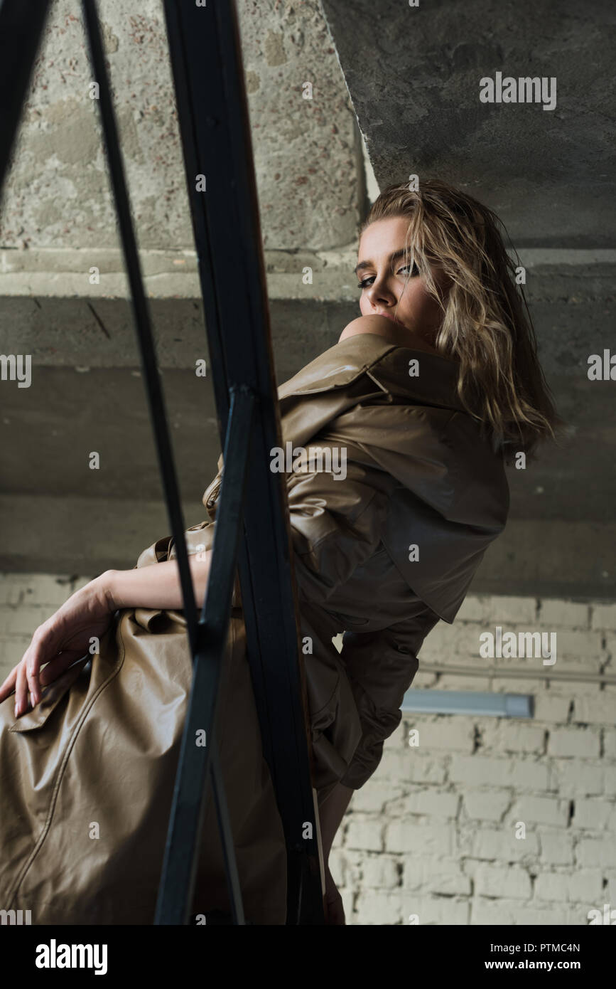 low angle view of stylish young model looking at camera while posing ...