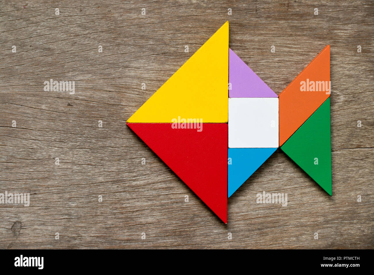 Colorful tangram puzzle in fish shape on wood background Stock Photo ...