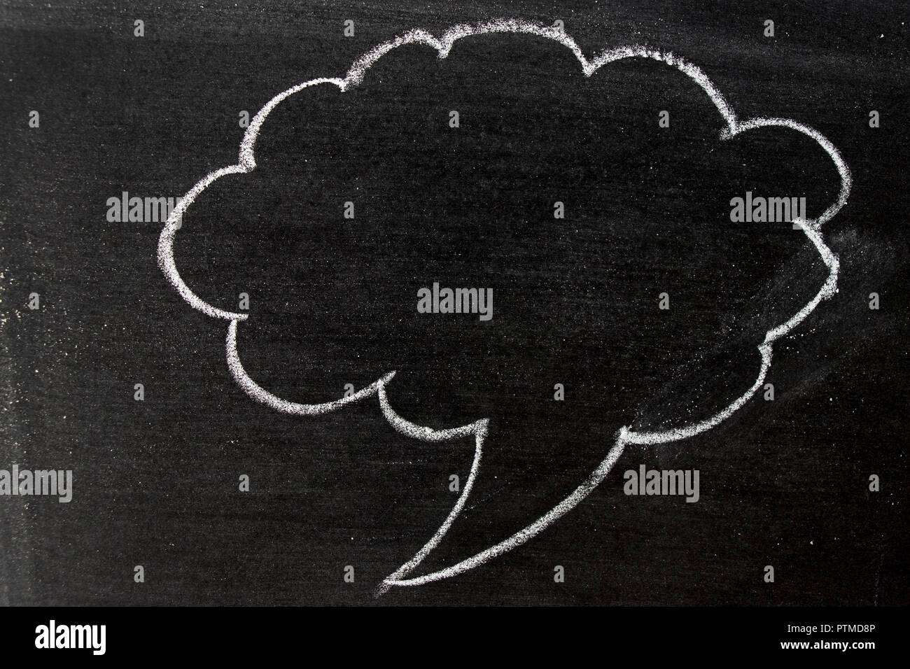 White color chalk hand drawing as speech bubble shape on black board ...