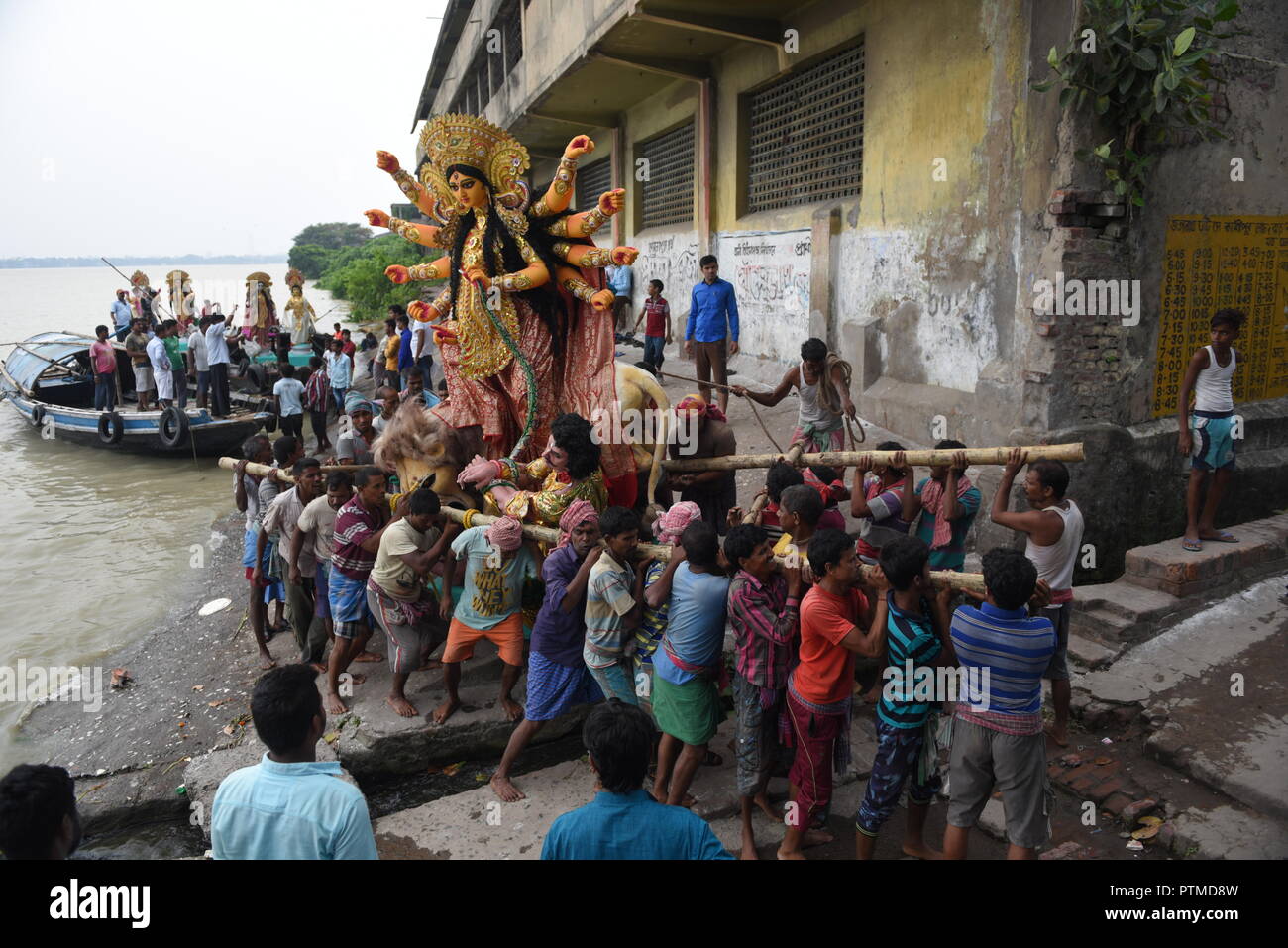 Hindu people are carrying the idol of Devi Durga over River Ganges on ...