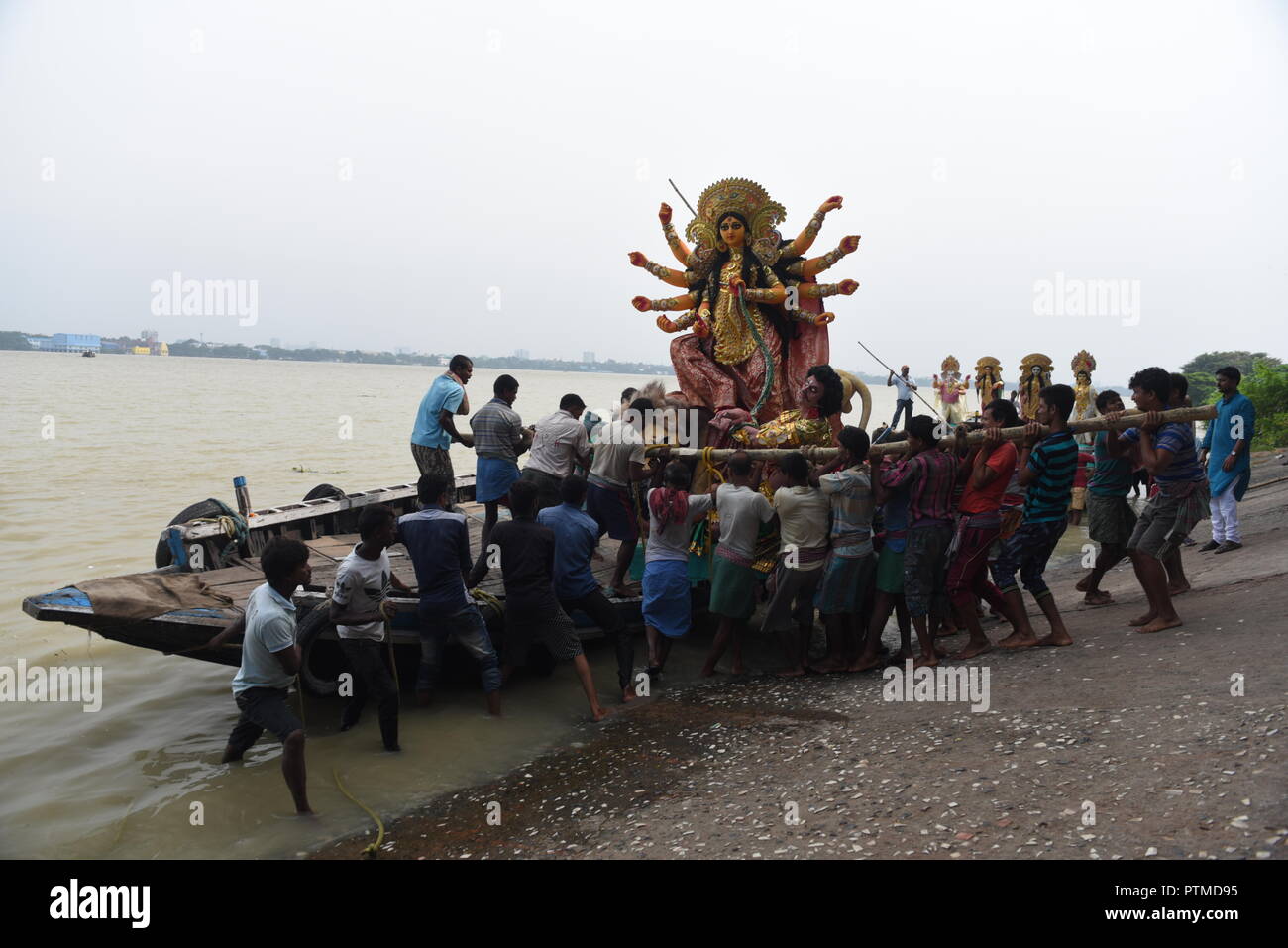 Hindu people are carrying the idol of Devi Durga over River Ganges on ...