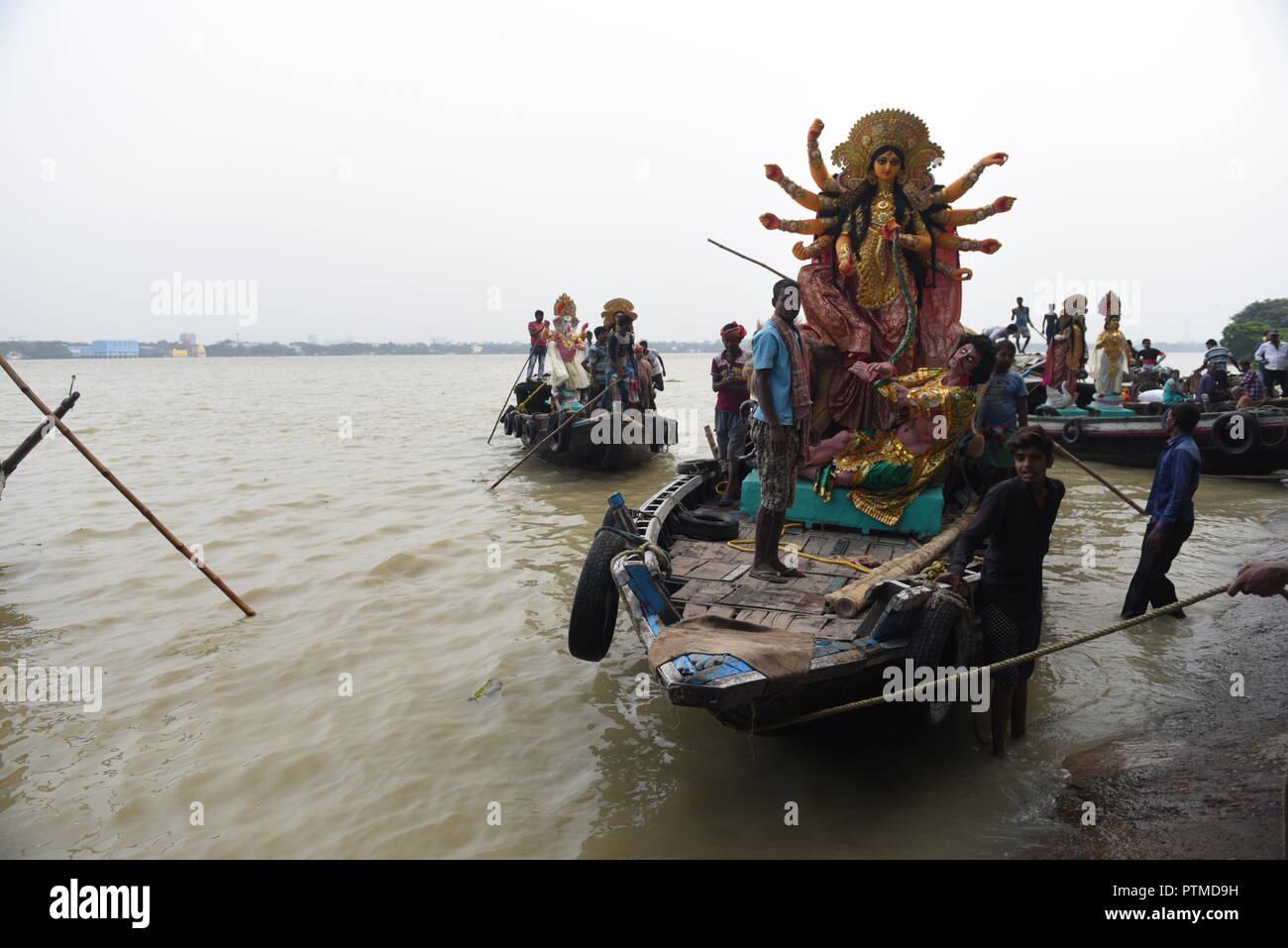 Hindu people are carrying the idol of Devi Durga over River Ganges on ...