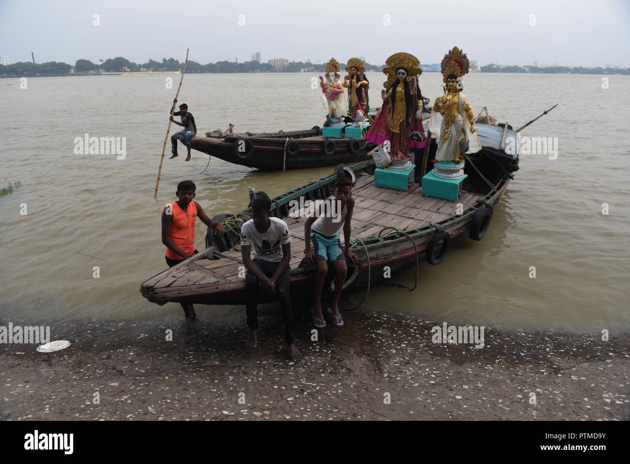 Hindu people are carrying the idol of Devi Durga over River Ganges on ...