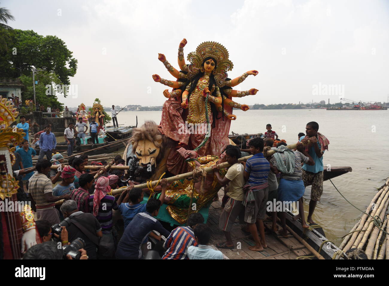 Hindu people are carrying the idol of Devi Durga over River Ganges on ...