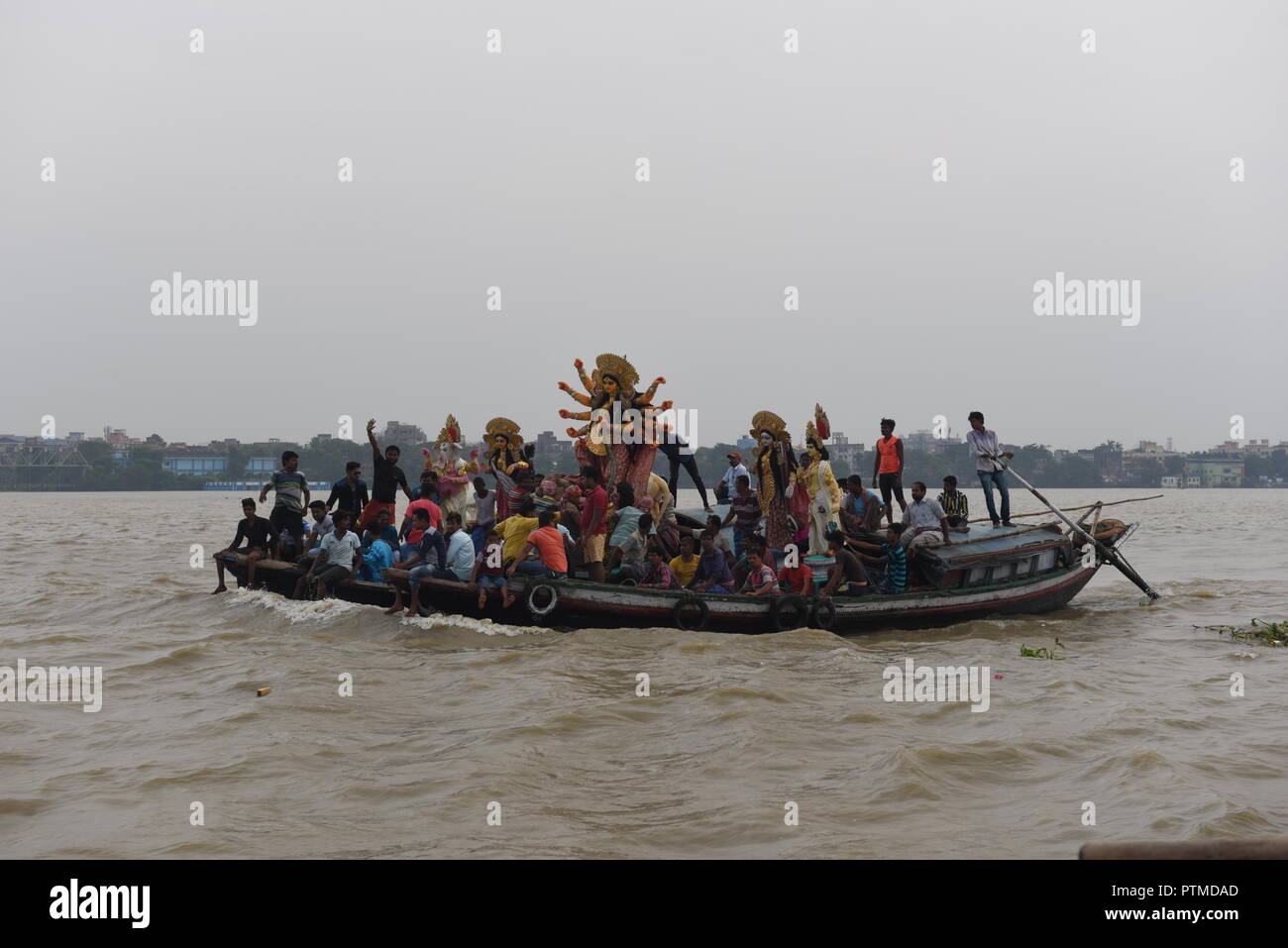 Hindu people are carrying the idol of Devi Durga over River Ganges on ...