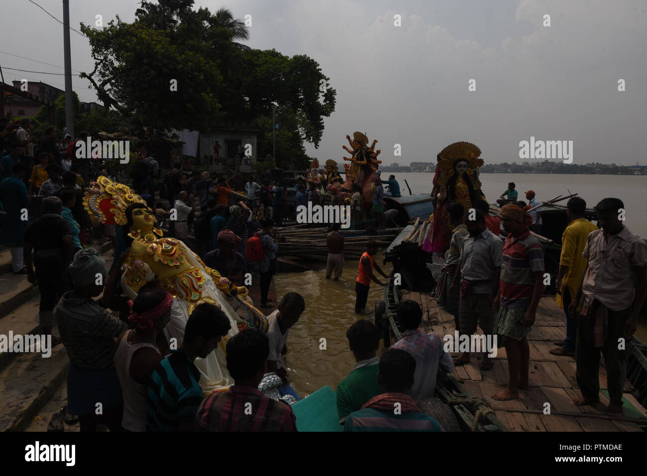 Hindu people are carrying the idol of Devi Durga over River Ganges on ...