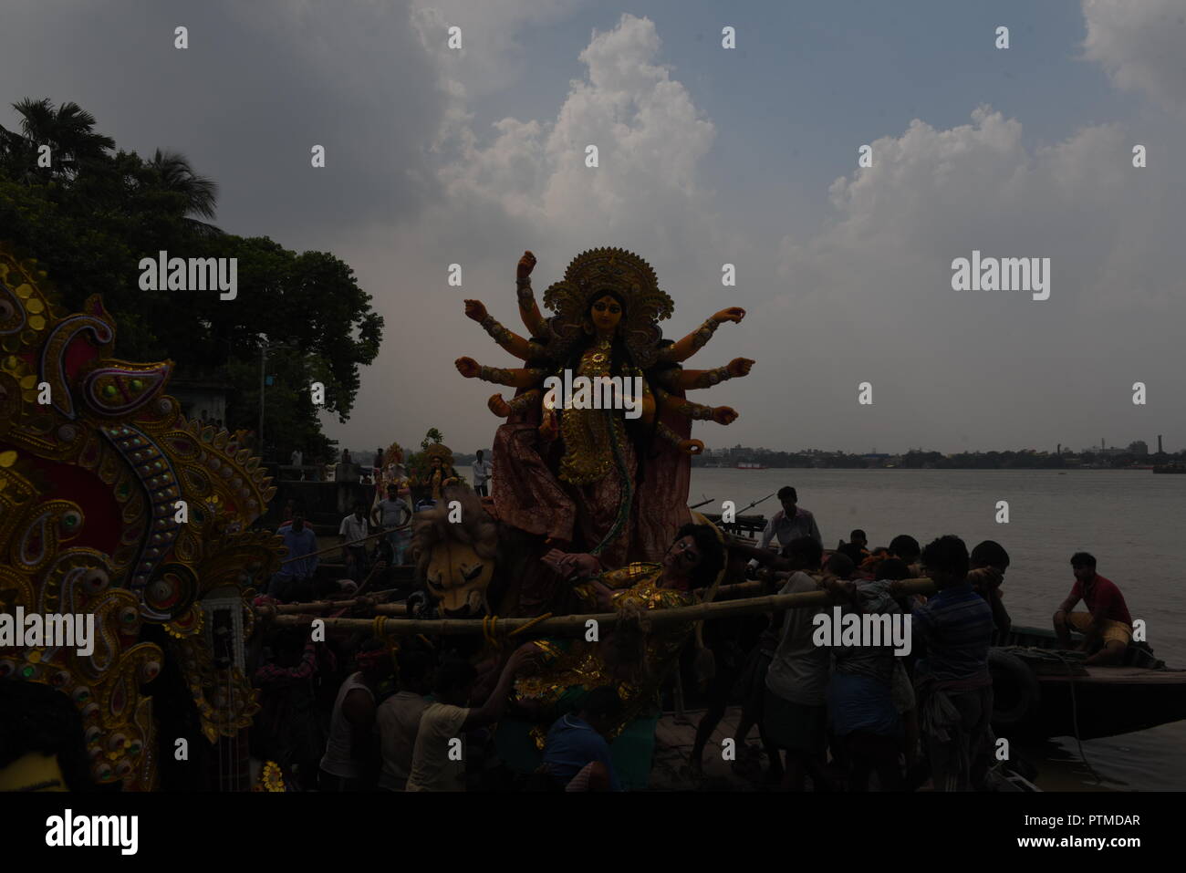 Hindu people are carrying the idol of Devi Durga over River Ganges on ...