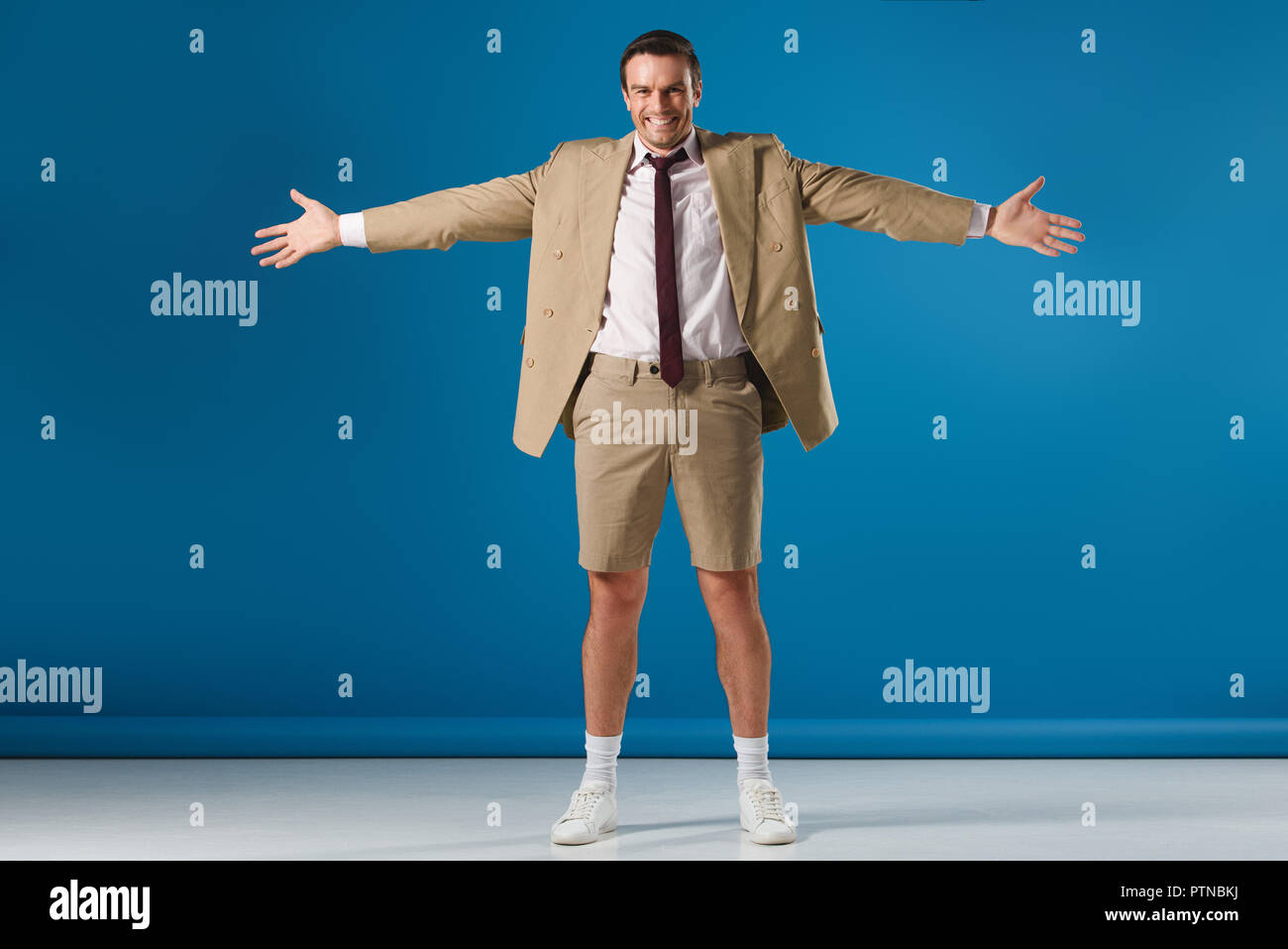 full length view of happy man in shorts standing with open arms and ...