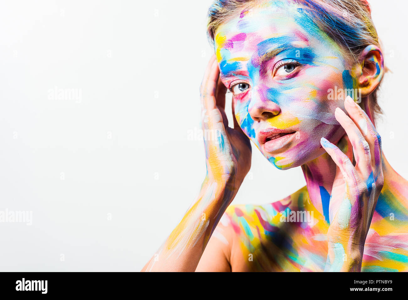 attractive girl with colorful bright body art touching face and looking ...