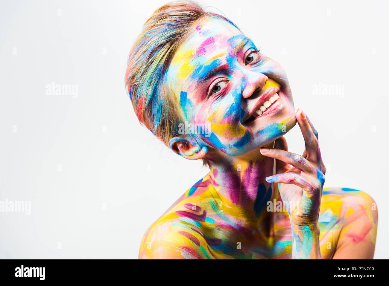 smiling attractive girl with colorful bright body art touching chin ...