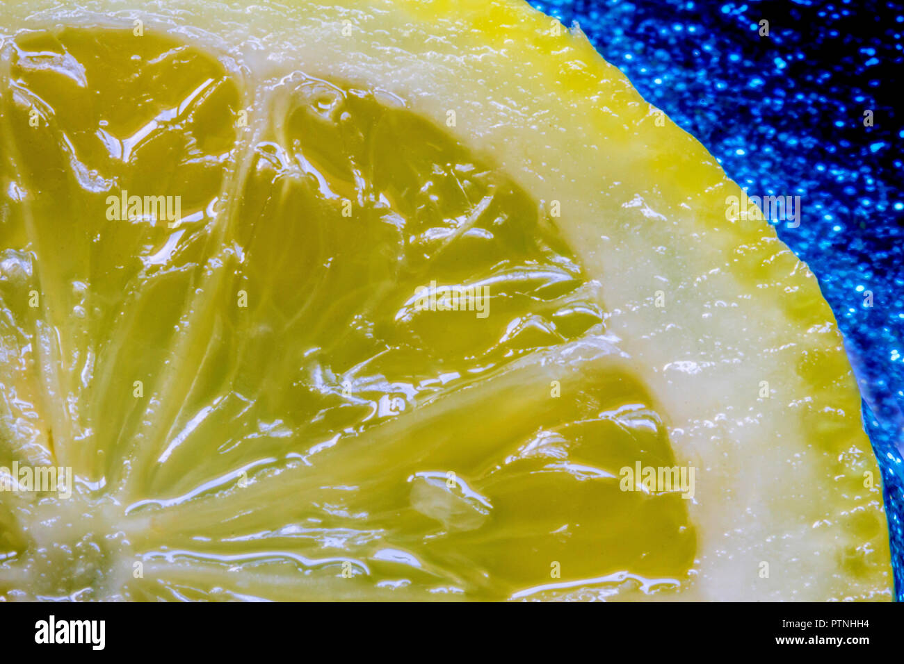 Lemon slice on a glittery blue background Stock Photo - Alamy