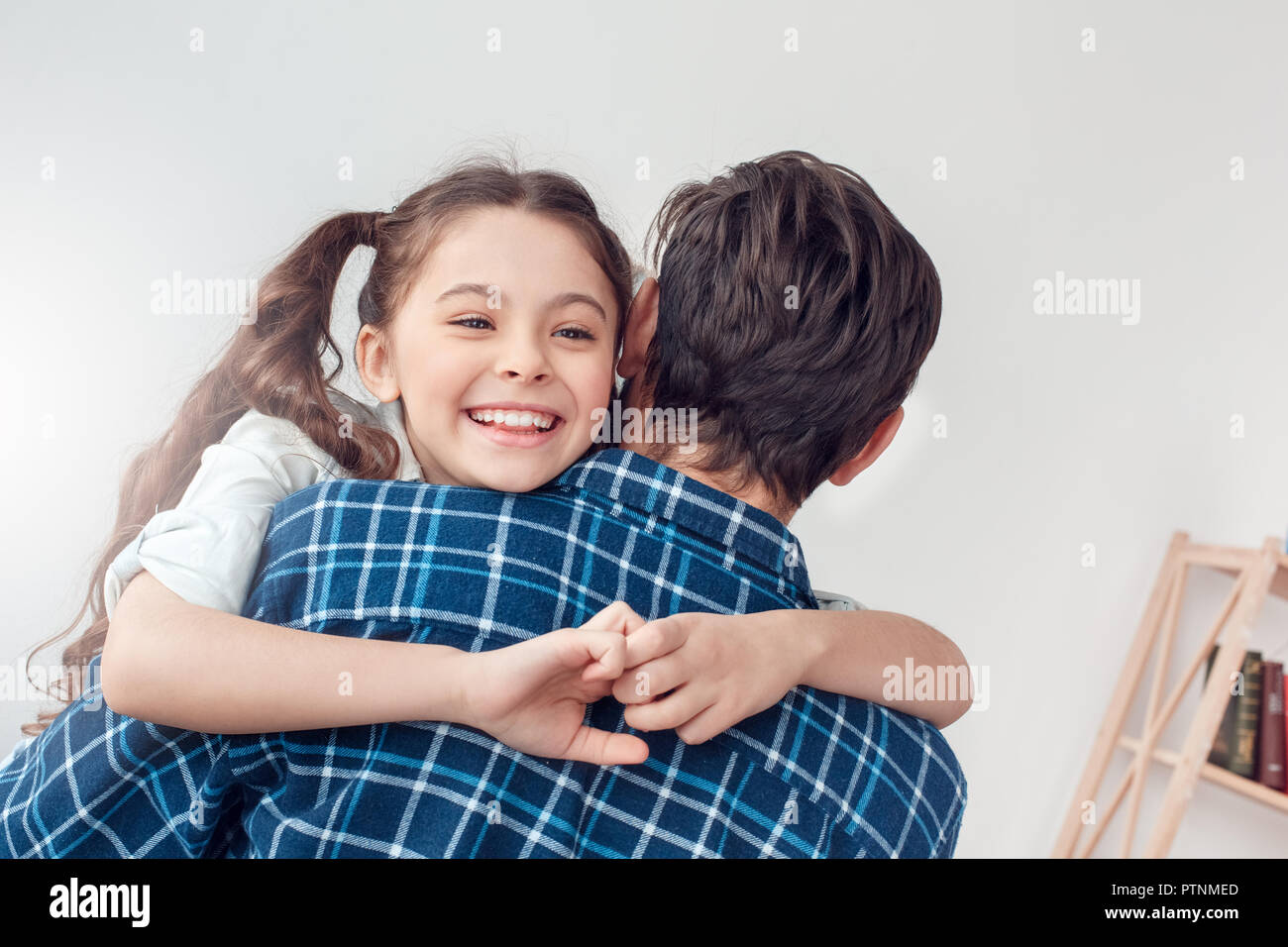 Man and little girl at home family time standing hugging daughter close ...