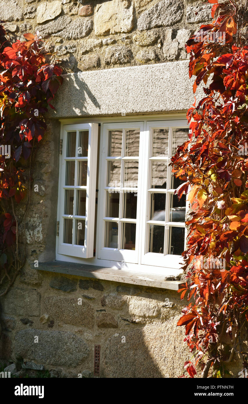 Typical cottage window of a Cornish granite cottage with ivy in the ...