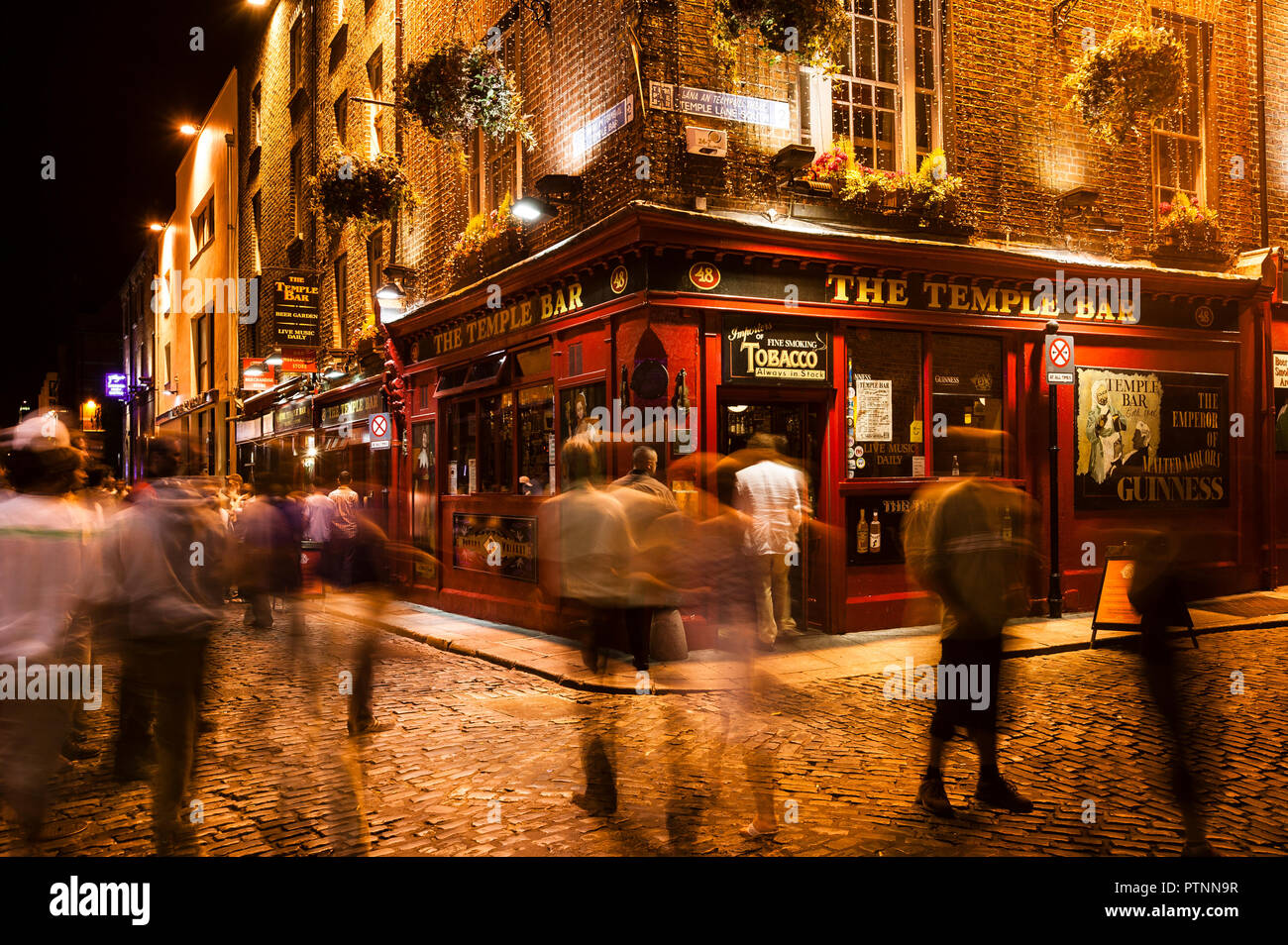 Busy nighttime street scene with blurred people around the Temple Bar ...