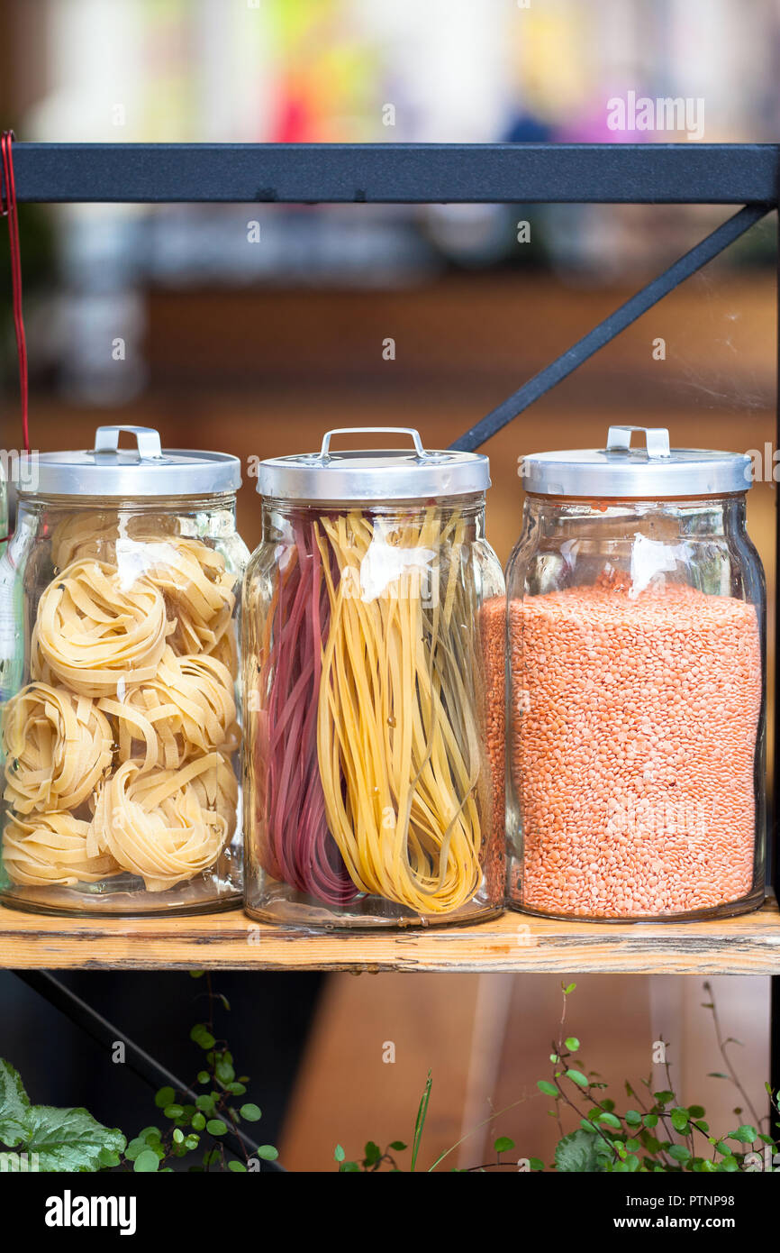 Pasta in the jar. On kitchen shelves are different kinds of pasta in ...