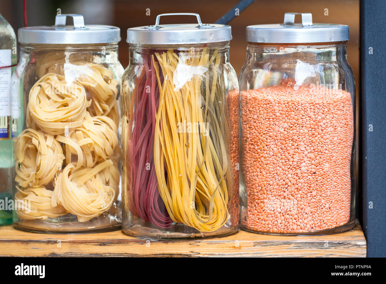 Pasta in the jar. On kitchen shelves are different kinds of pasta in ...