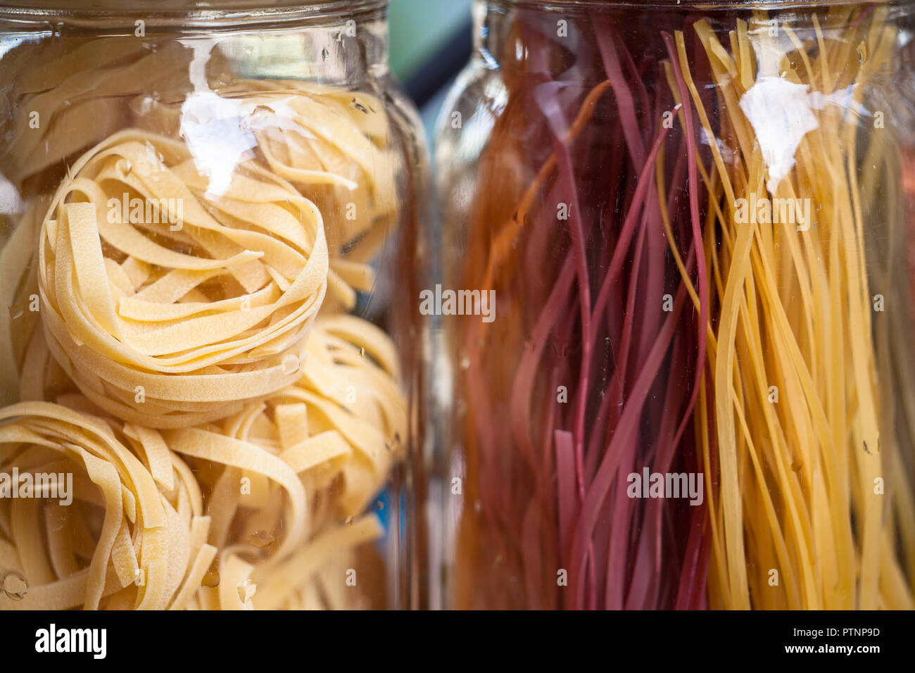 Pasta in the jar. On kitchen shelves are different kinds of pasta in ...