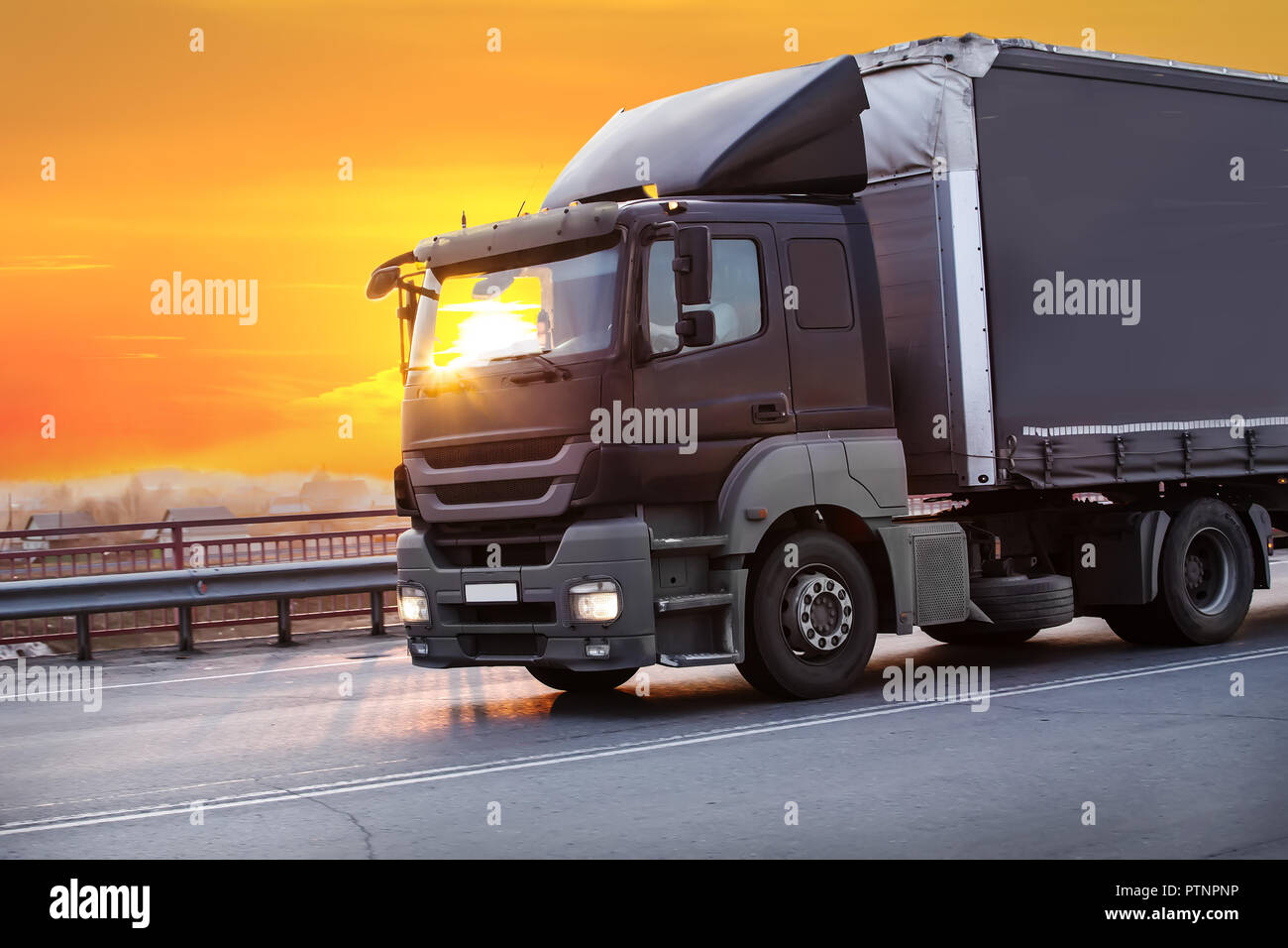 truck goes on highway in evening on sunset Stock Photo - Alamy