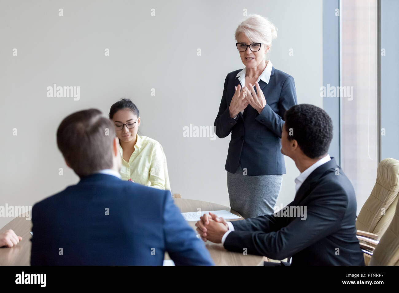 Female employee standing making speech at briefing Stock Photo - Alamy