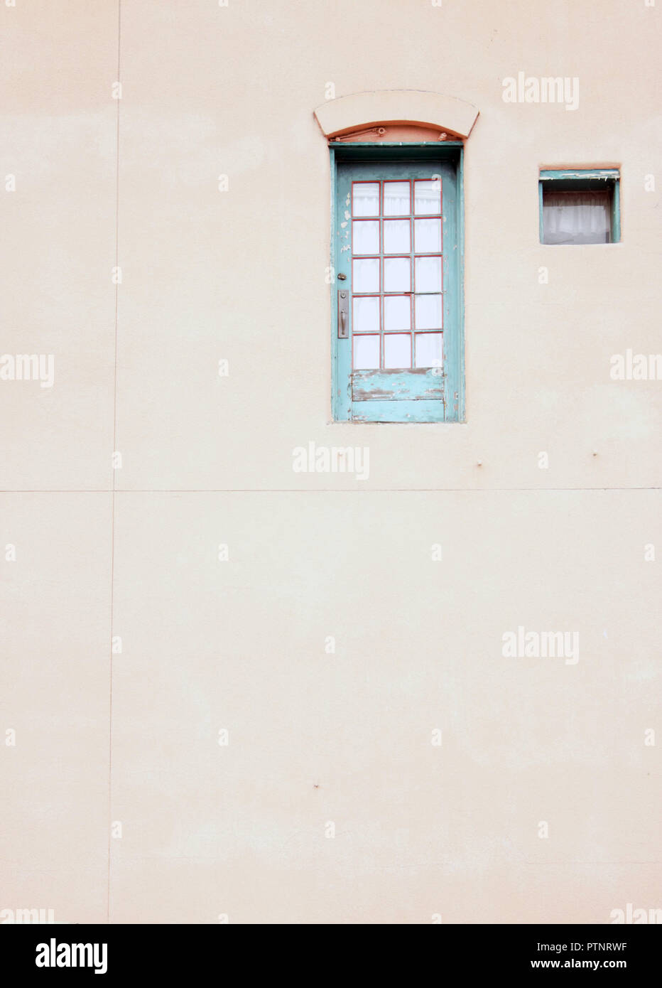 A second story wood door with no stairs on the side of an old building ...