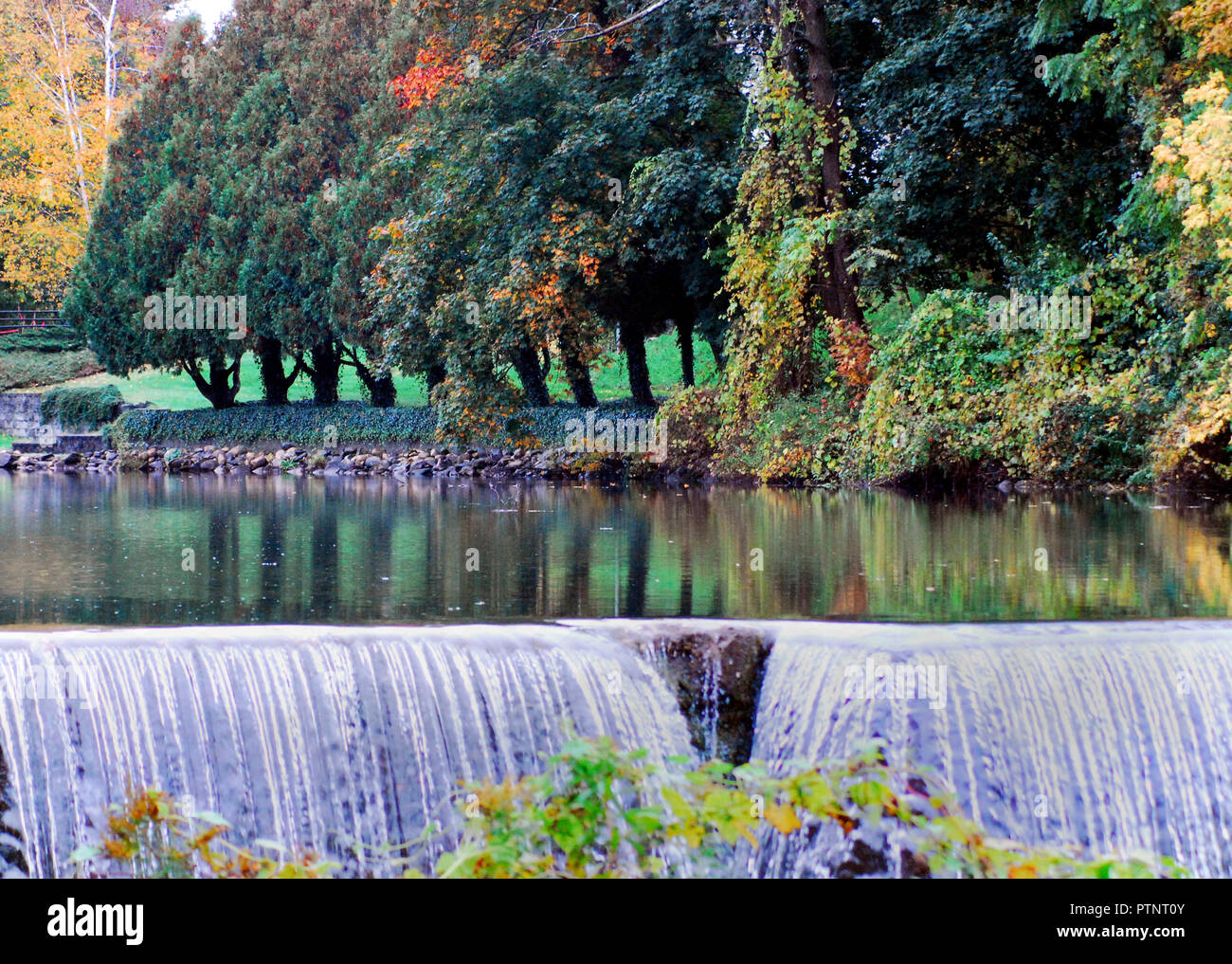 Lake reflections and a waterfall add to the beauty of the fall colors ...