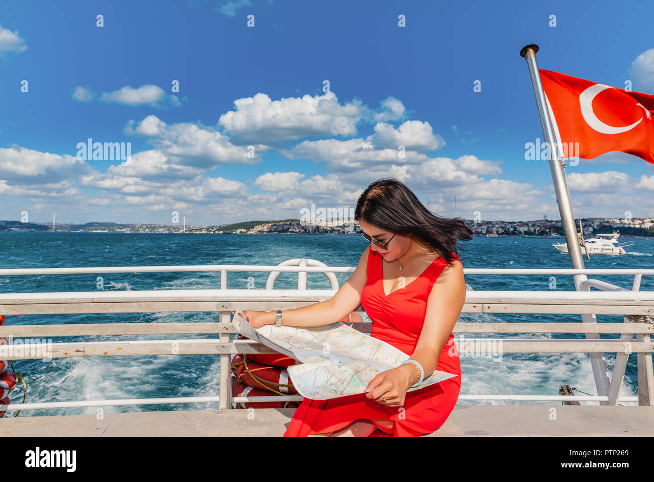 Beautiful Chinese woman looks at Istanbul map while cruising in ...