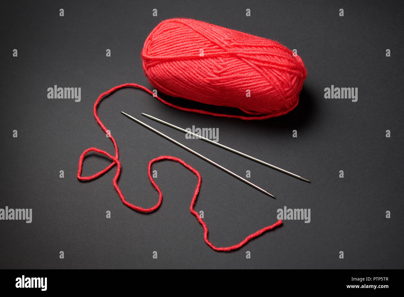 red ball of woolen thread for knitting on black background Stock Photo ...