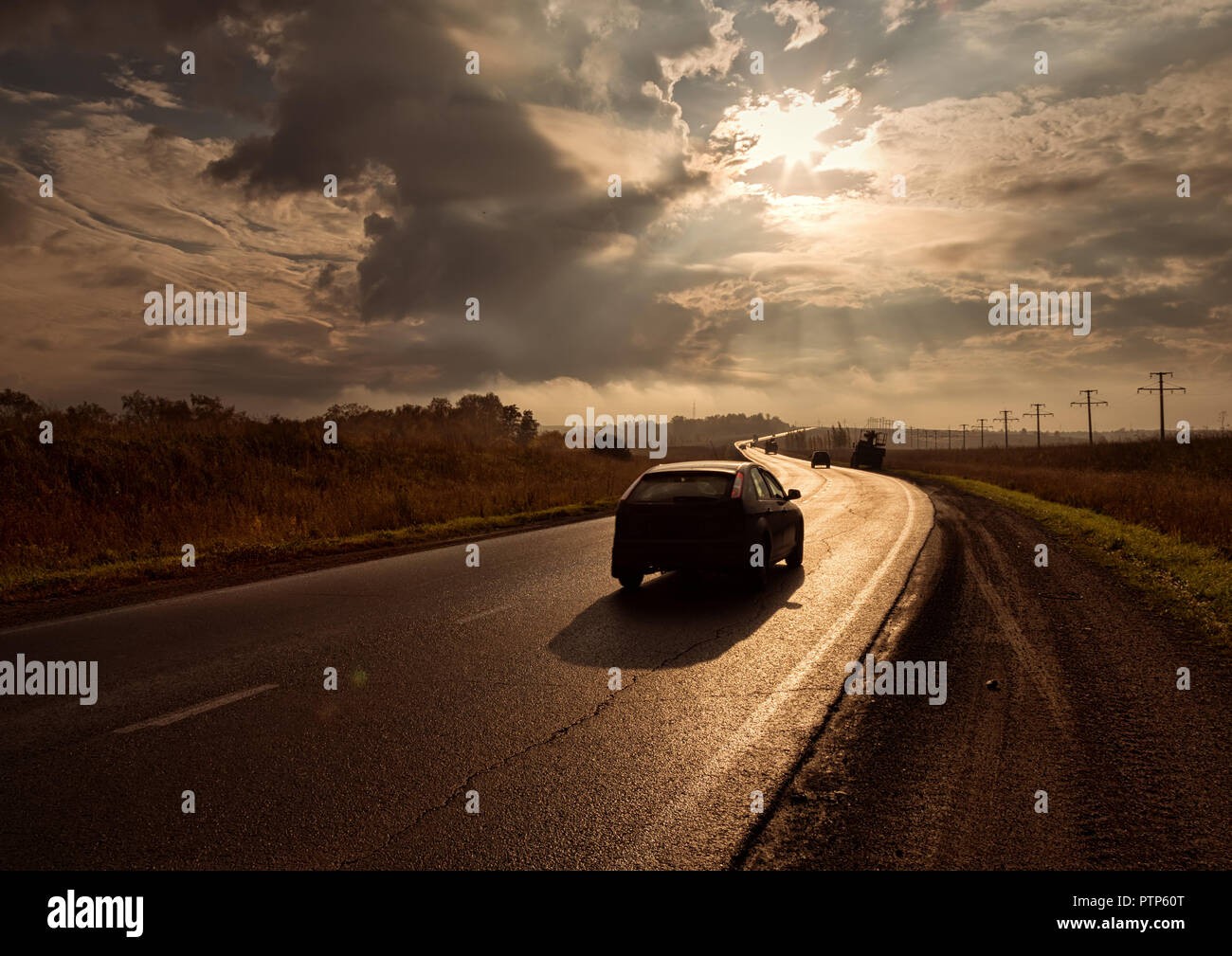 sunset road glistens in the sun strives forward. lonely car on a ...