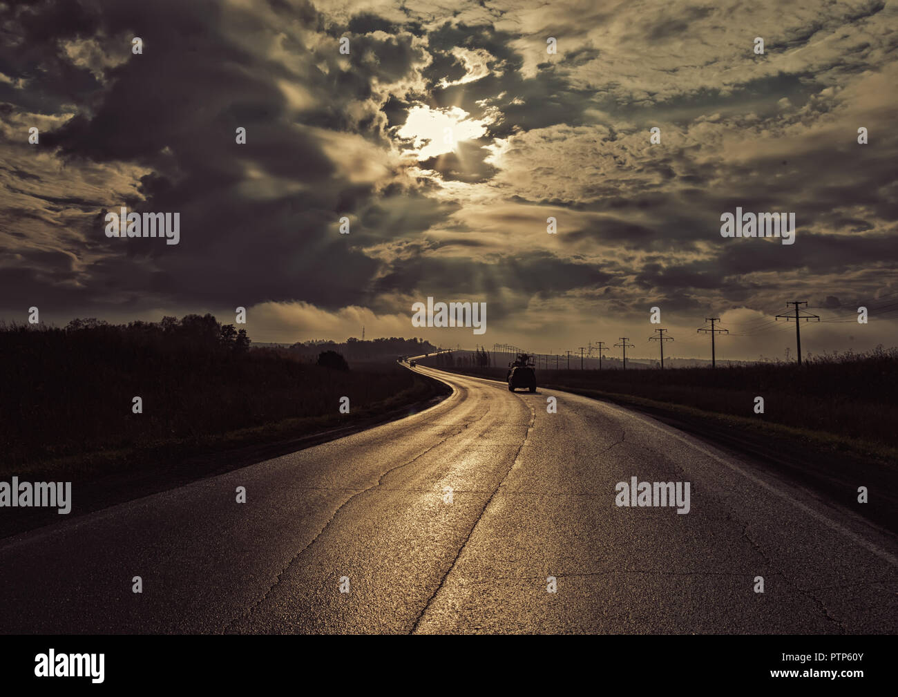 sunset road glistens in the sun strives forward. lonely car on a ...