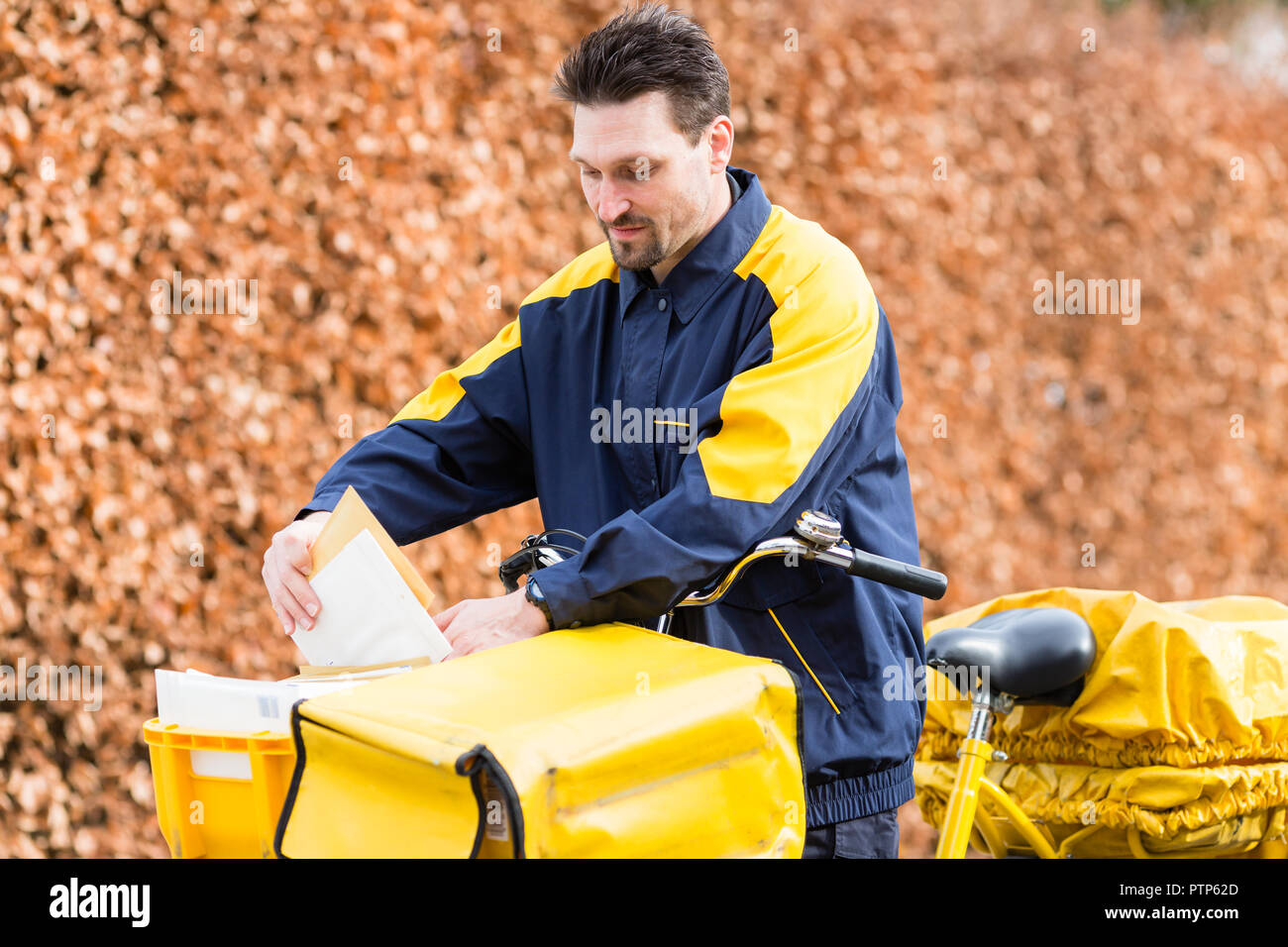 Postman riding his cargo bike carrying out mail in the neighborhood ...