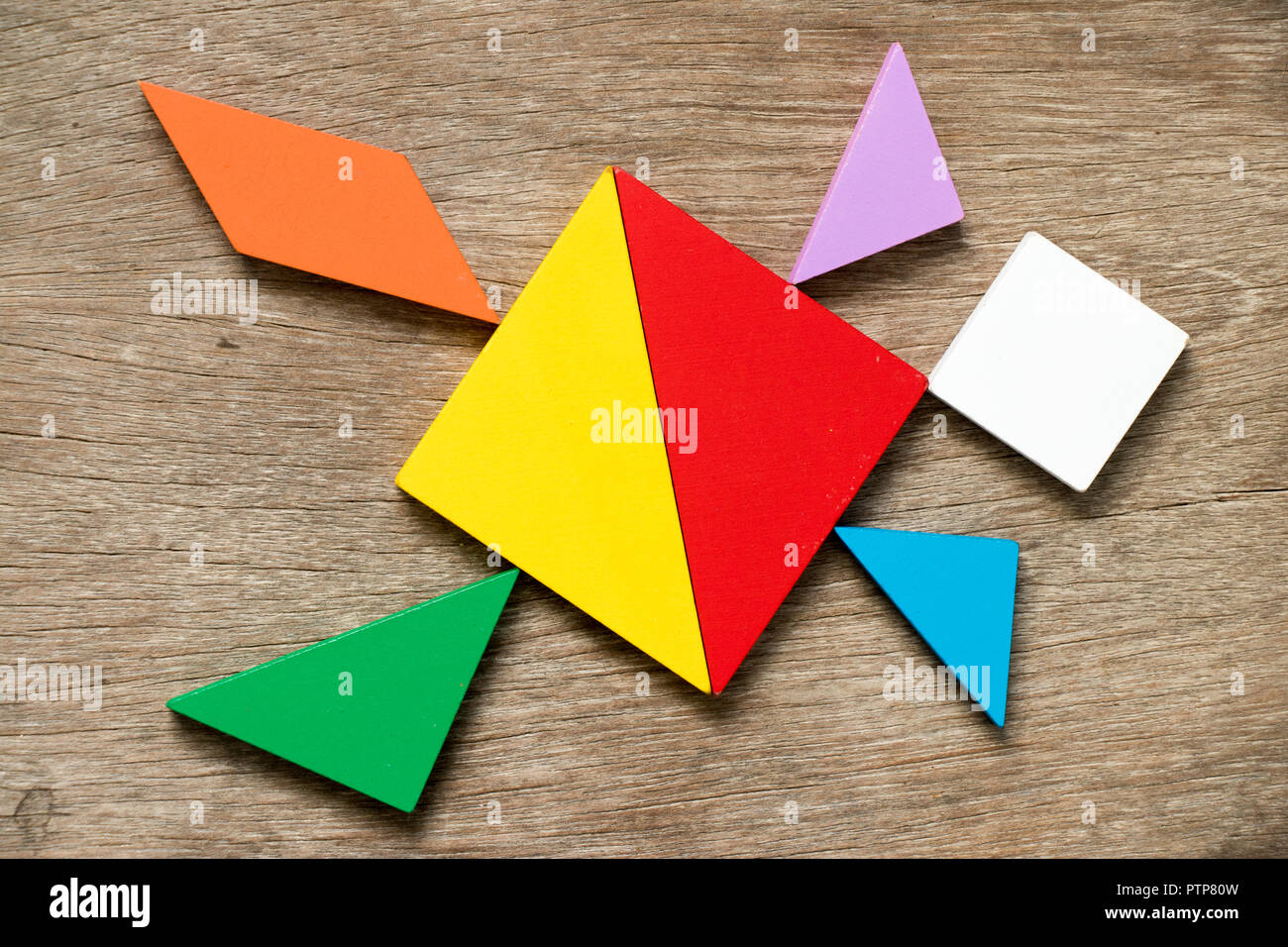 Colorful tangram puzzle in swimming turtle shape on wood background ...