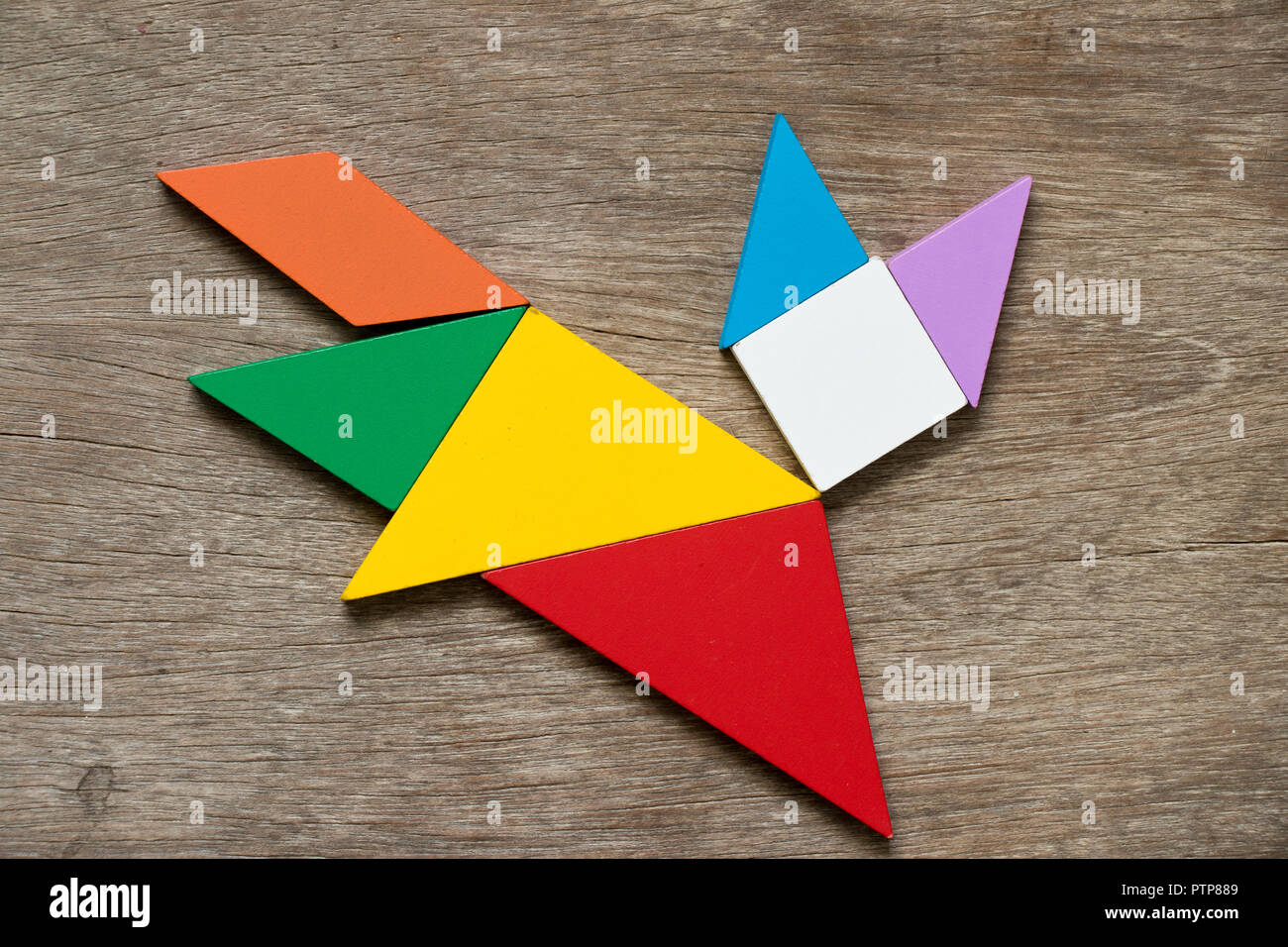 Colorful tangram puzzle in running cat or fox shape on wood background ...
