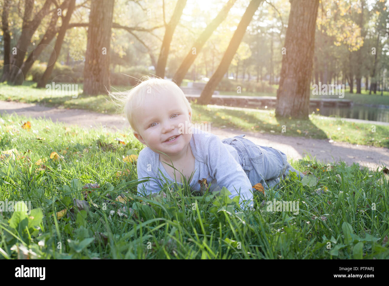 Kid lying on the green grass outdoor. Little child boy portrait Stock ...